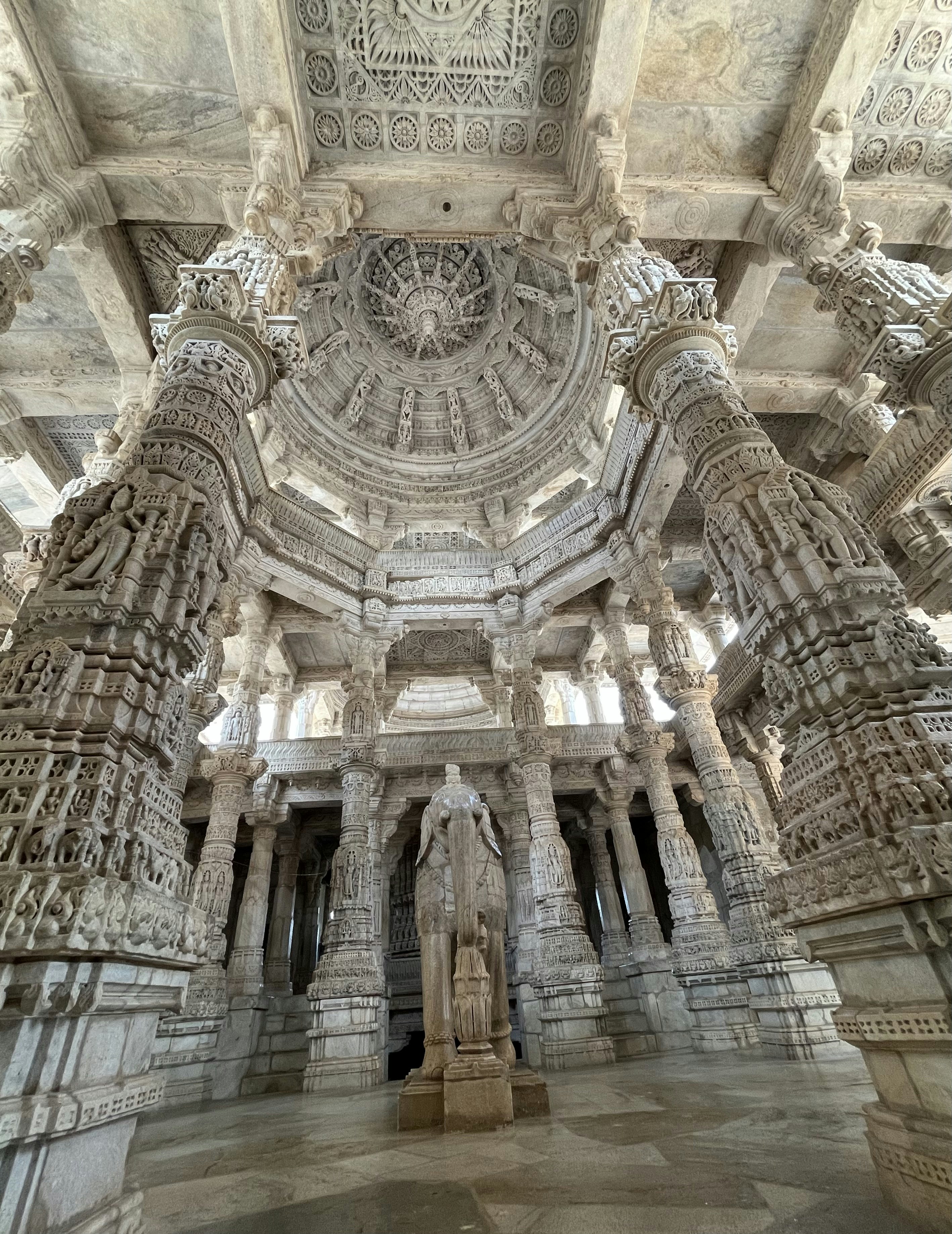 Whispering Colonnade: Central Statue Surrounded by Carved Pillars