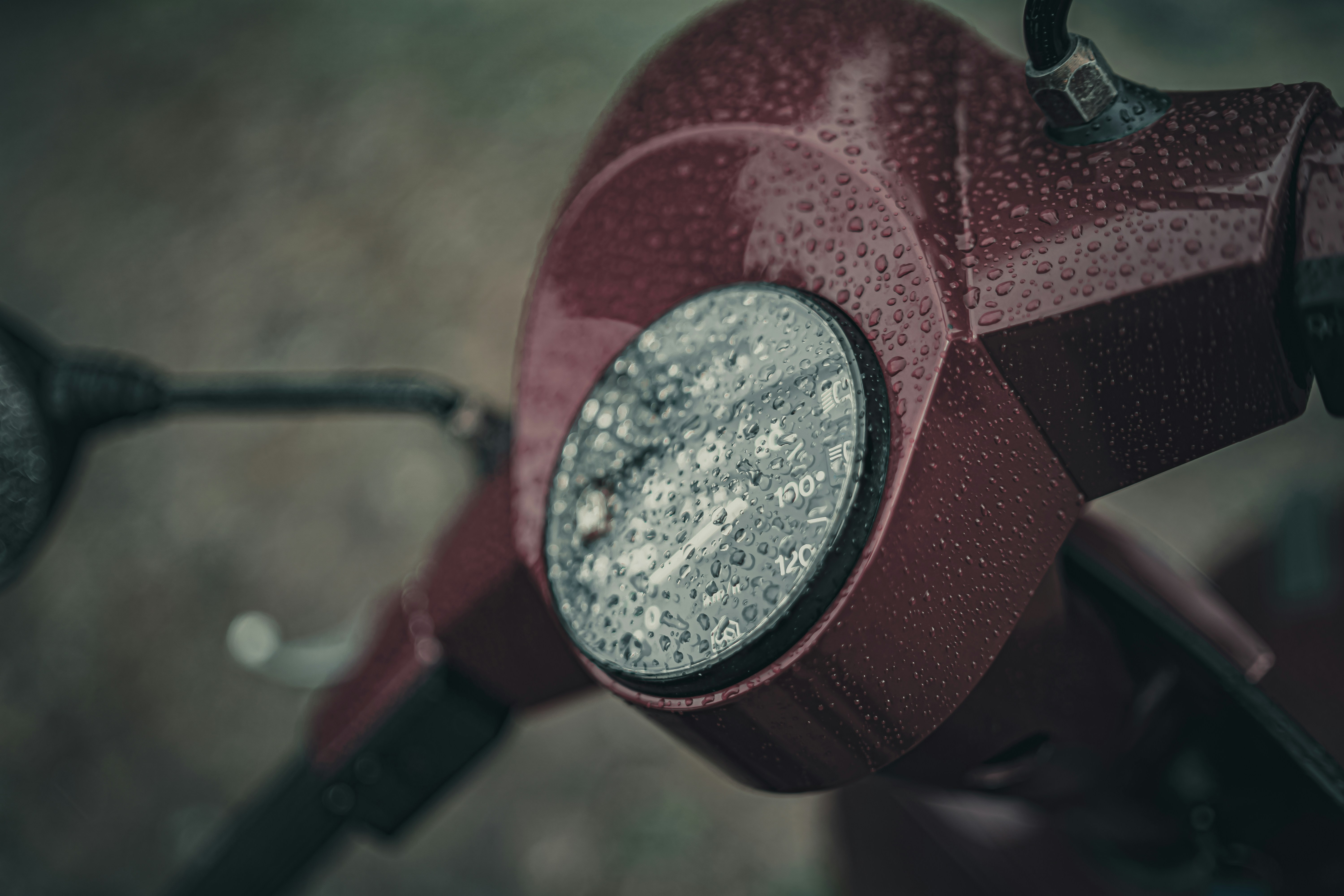 Rain-Kissed Headlight: Close-Up of Wet Red Scooter Detail