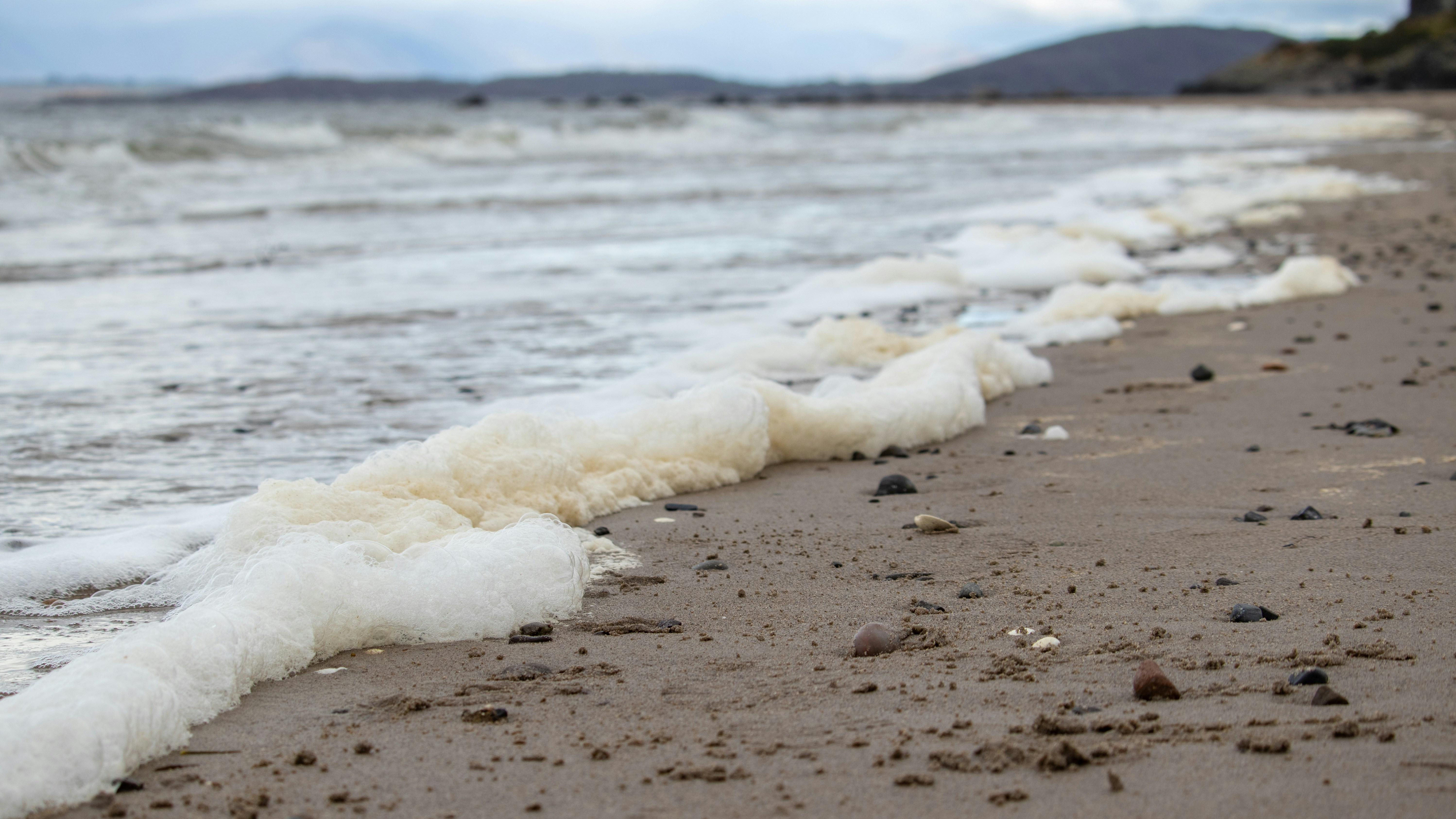 Sea foam at Ganavan Sands beach in Oban