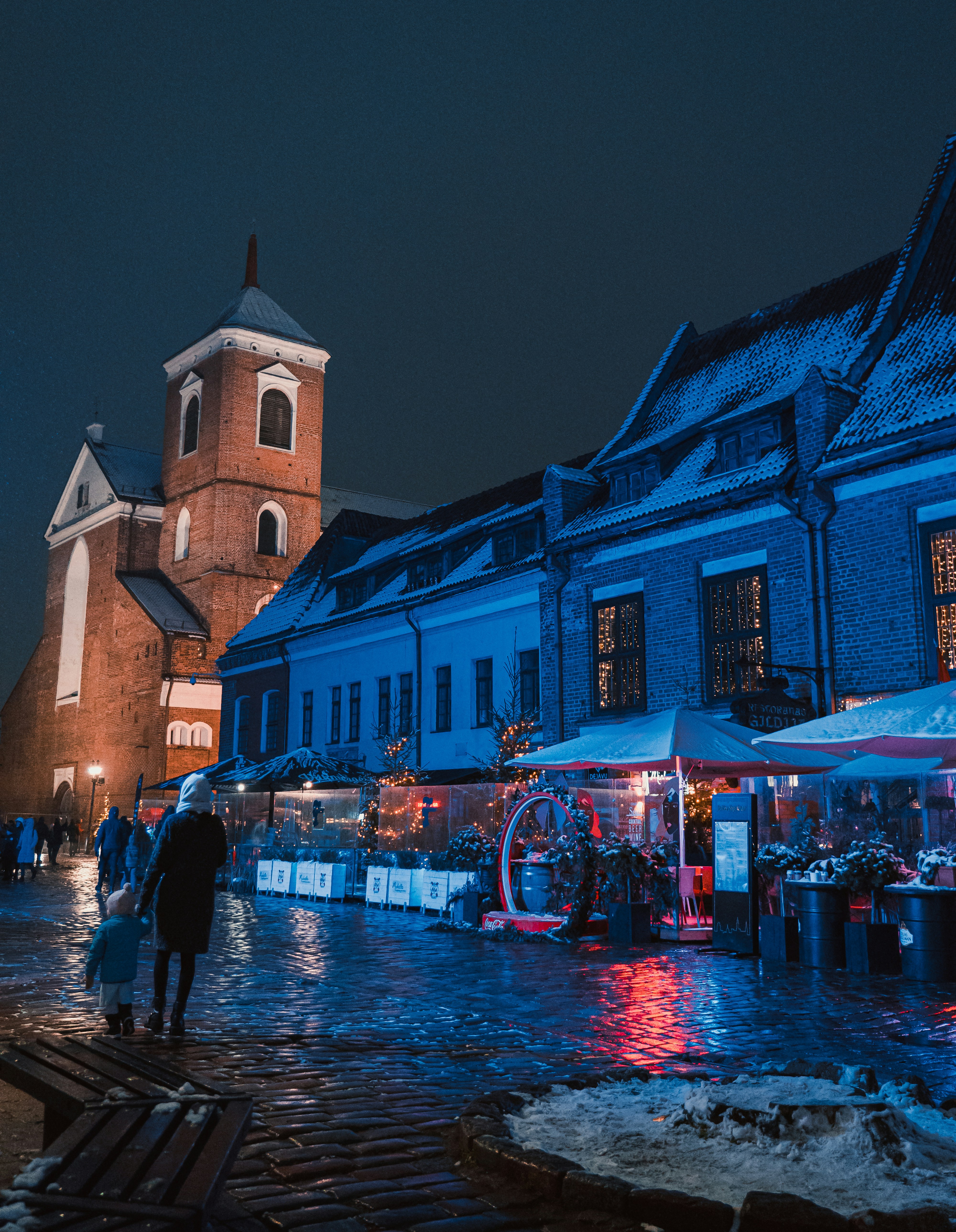 Blue Hour Courtyard: Market Lights and Snow-dusted Cobblestones by the Brick Clocktower