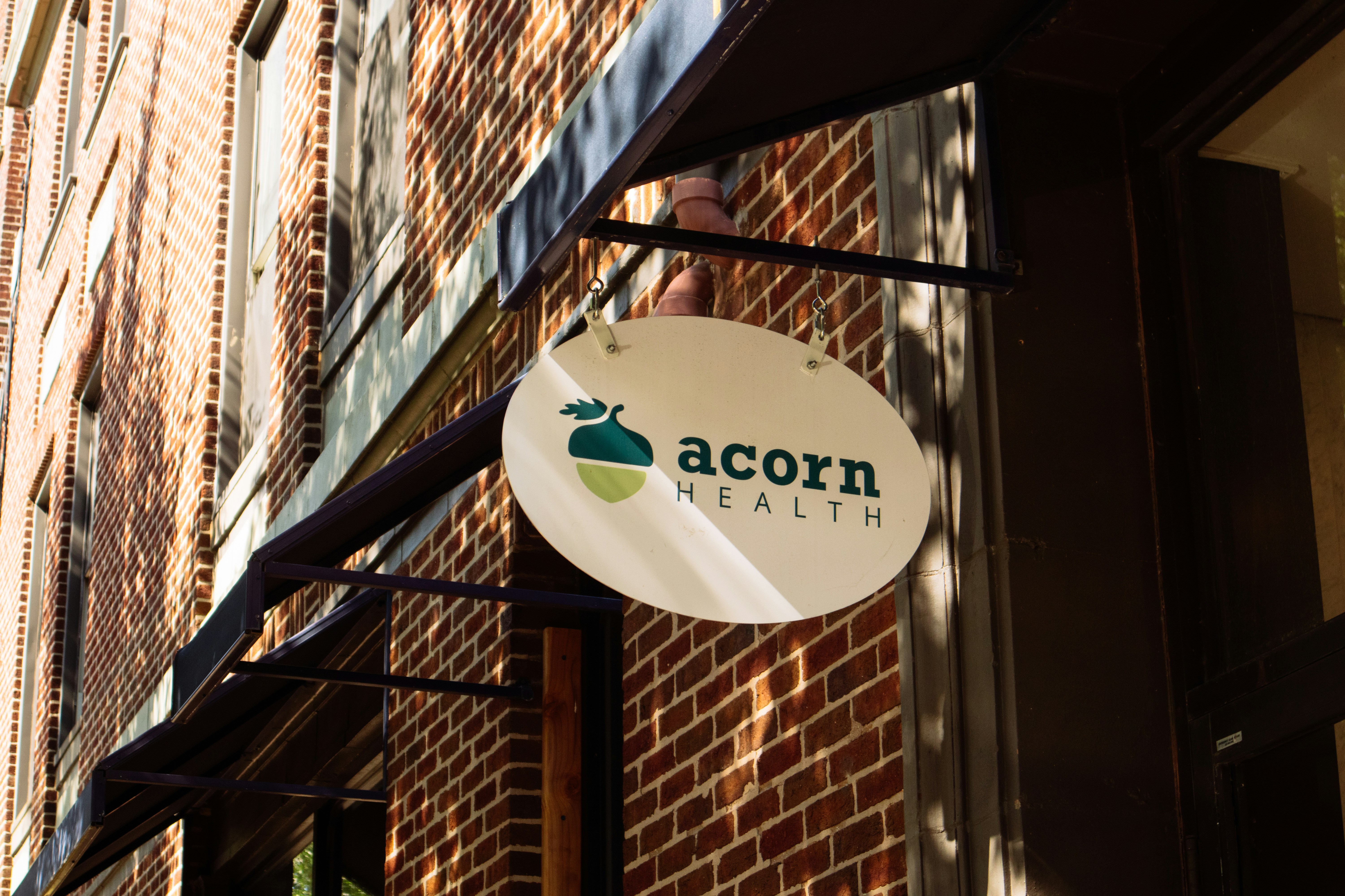 Acorn Health Signboard Adrift on a Brick Facade