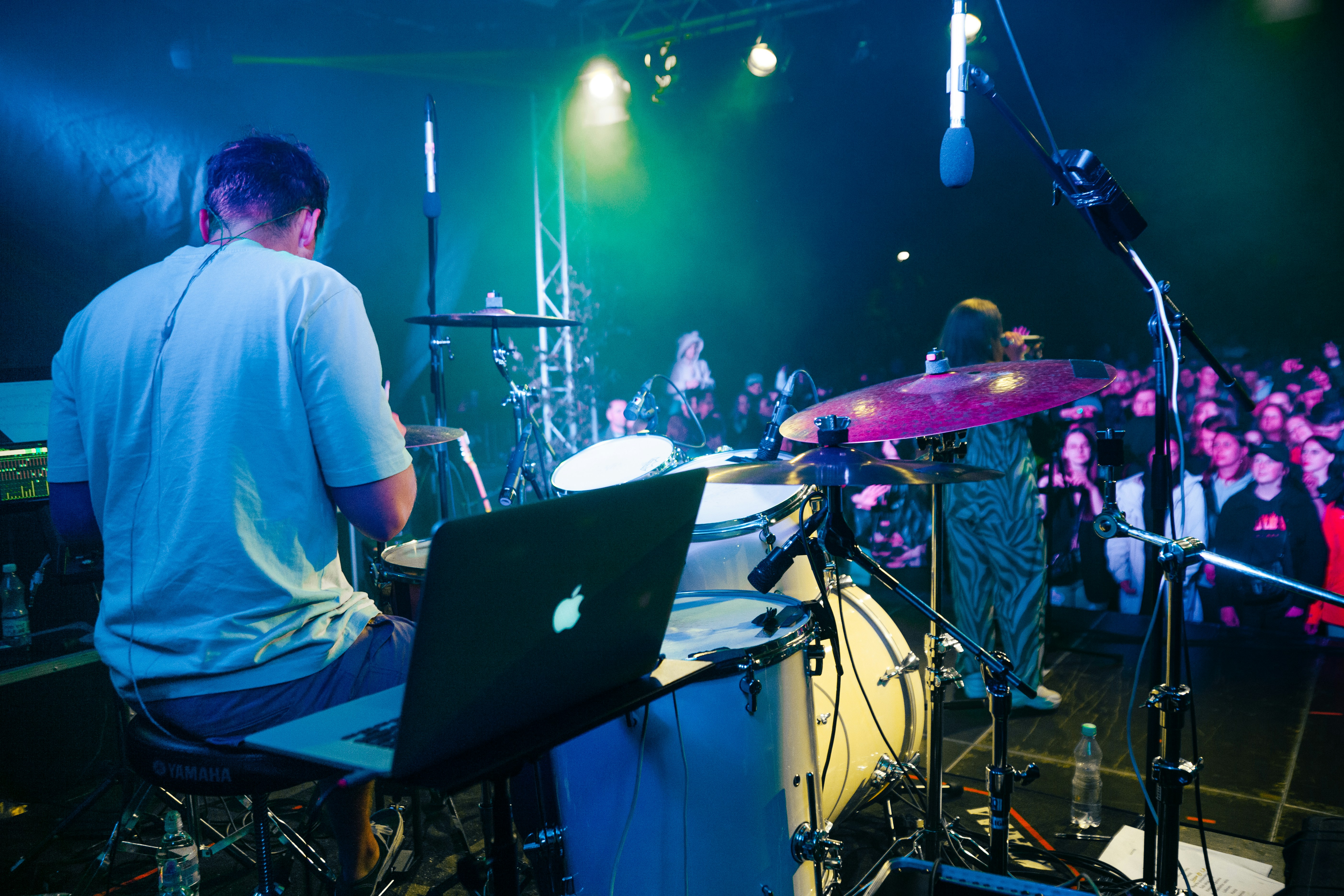 Stage Quiet Pulse: Drummer at the Kit Under Neon Haze