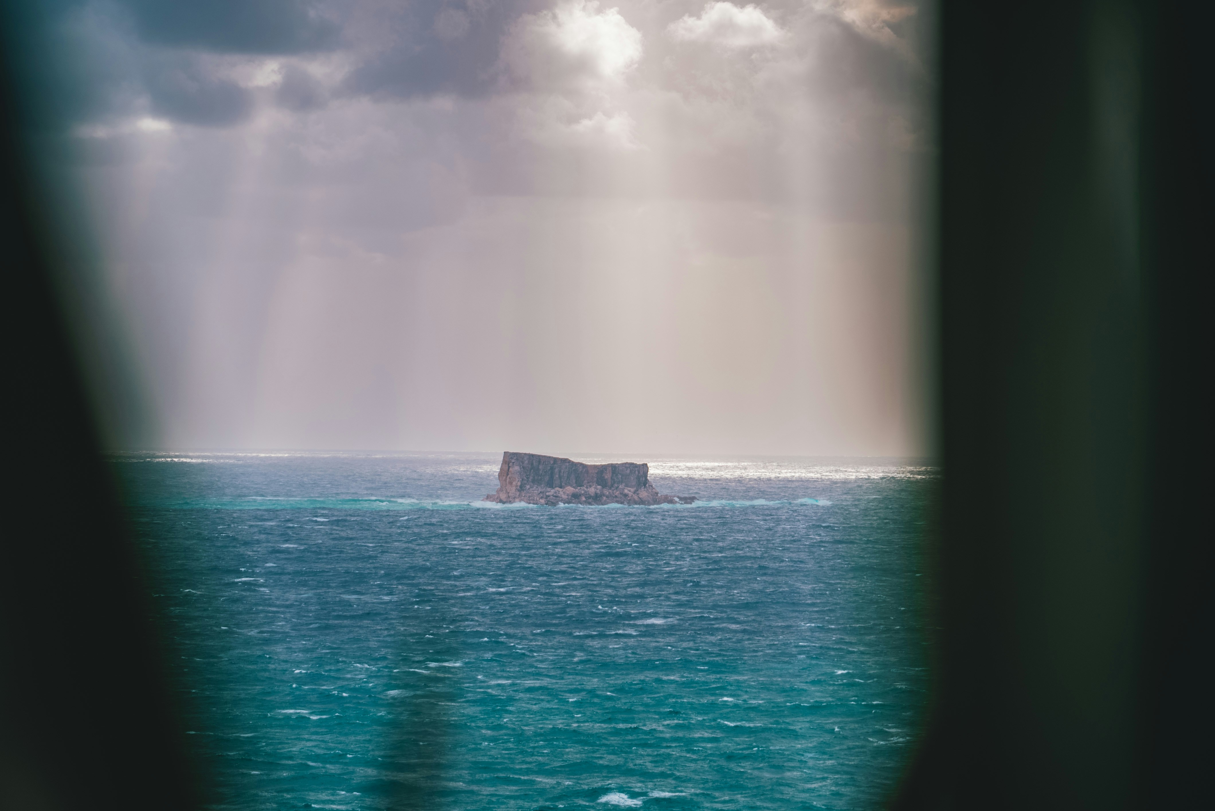 Window-framed island in sunlit turquoise sea