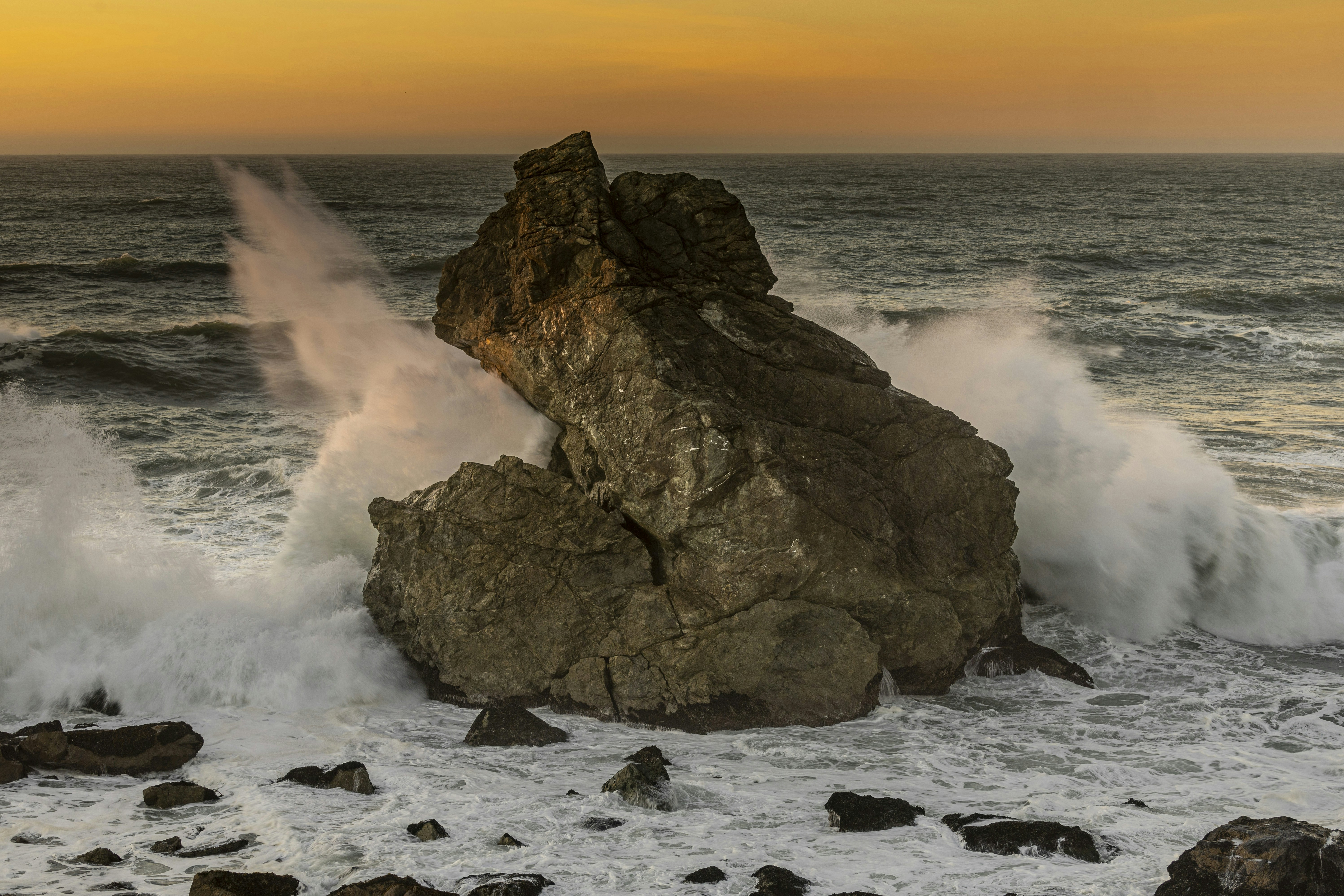 Un gros rocher sur une plage photo – Photo Le coucher du soleil ...