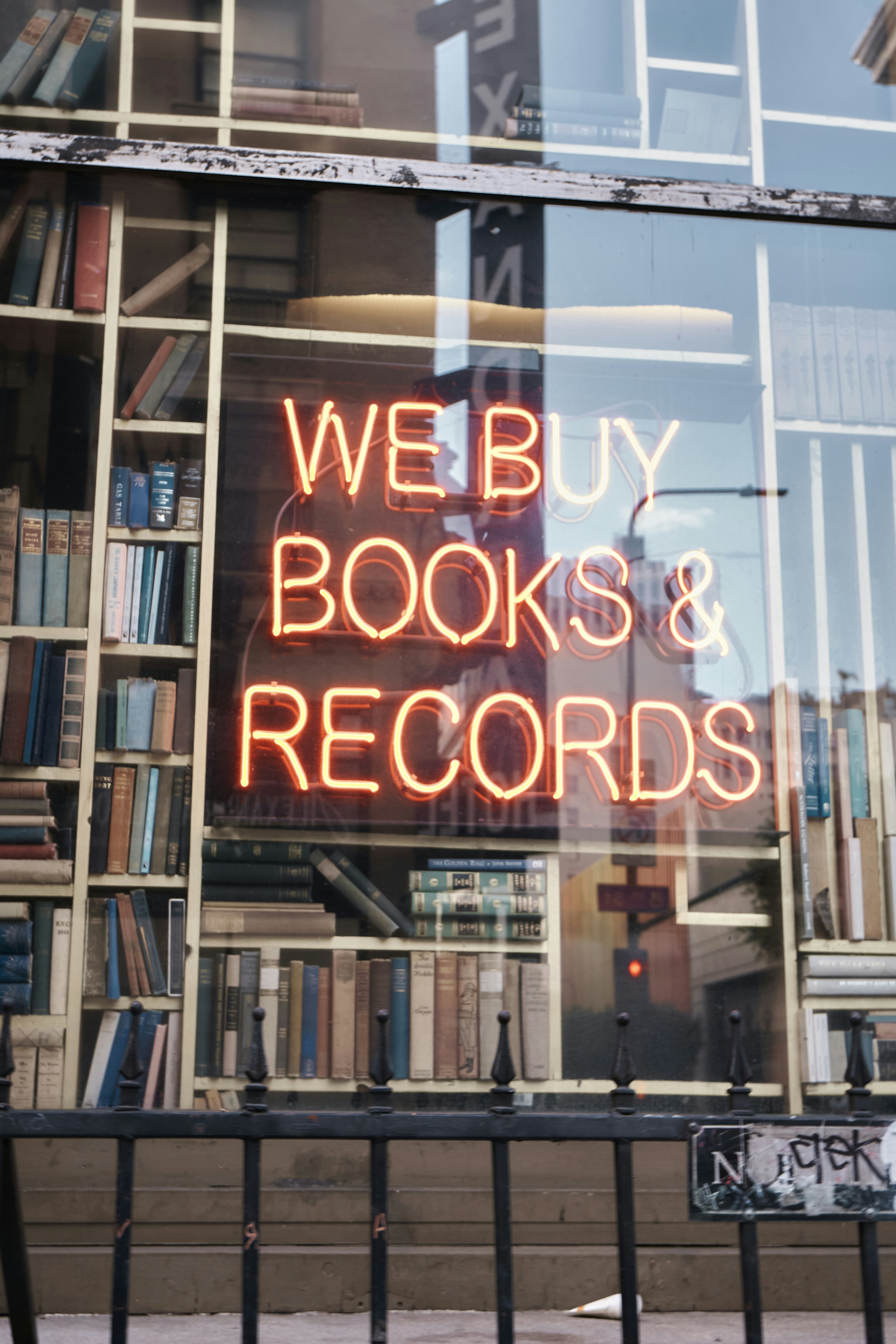 Neon Sign in a Bookshop Window Reflecting a City
