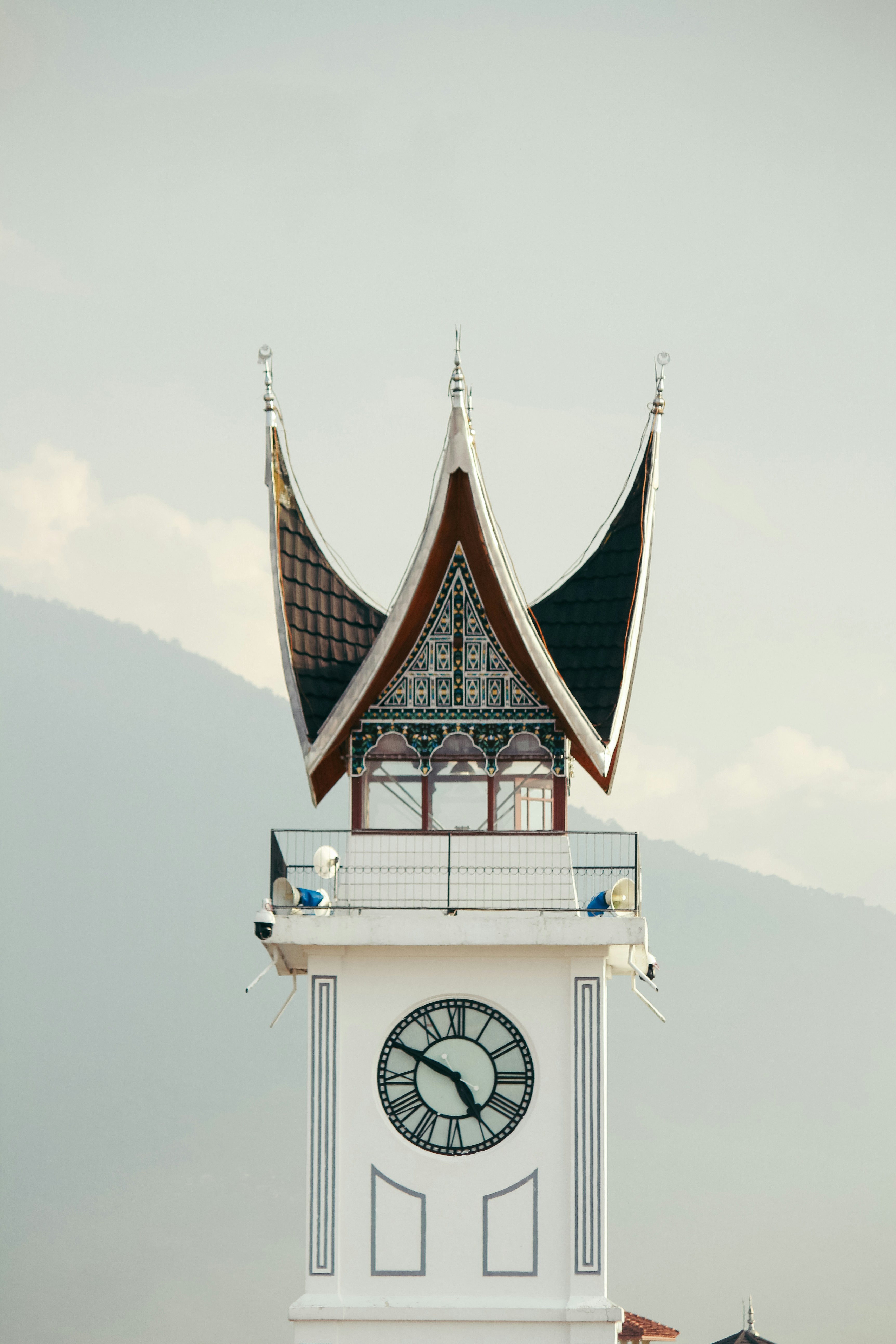 Twin-Curved Roofs Crown a Clocktower Against Misty Mountains