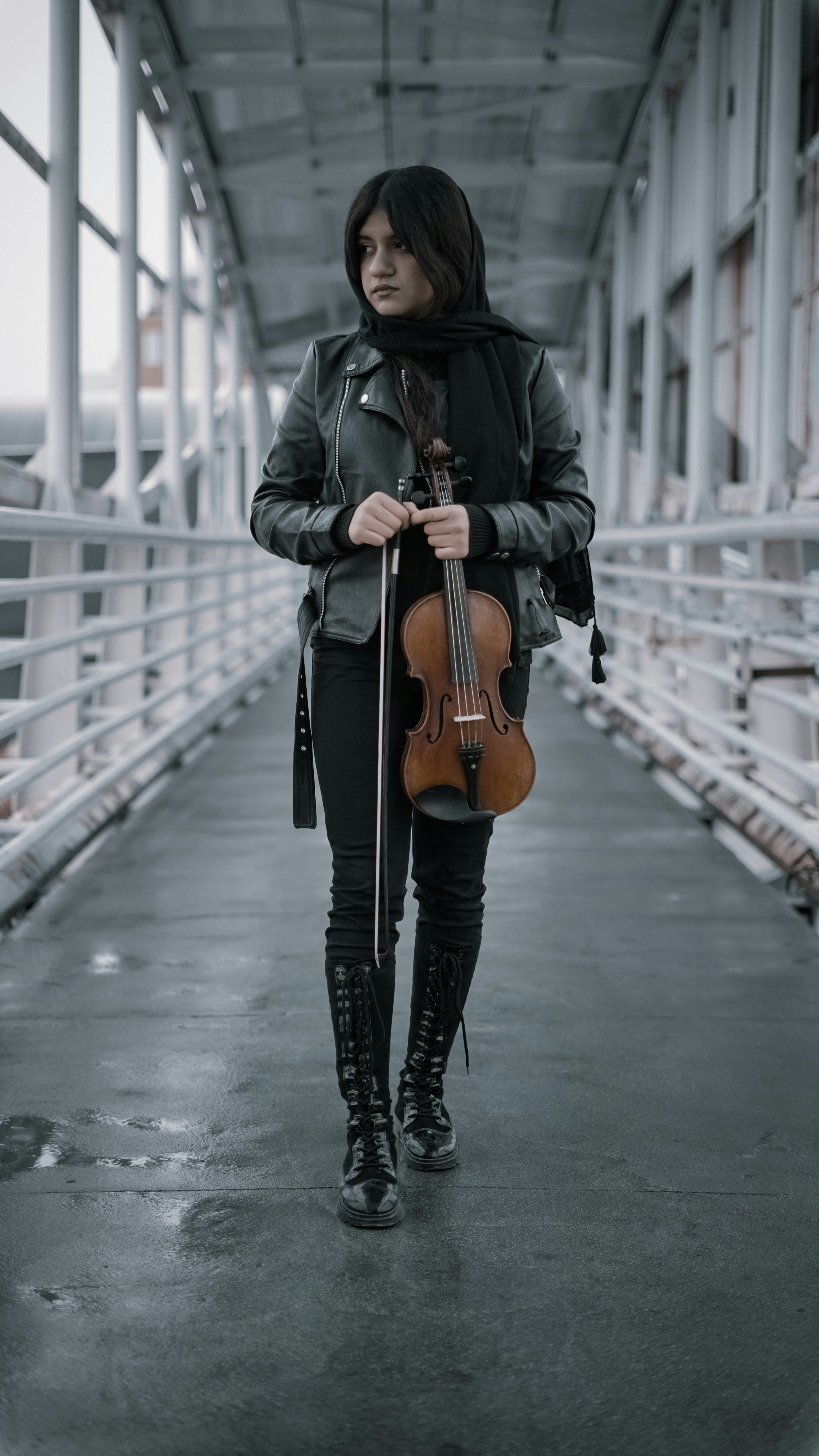 Steel-Span Serenade: A Solo Violinist Pauses on a Moody Urban Bridge