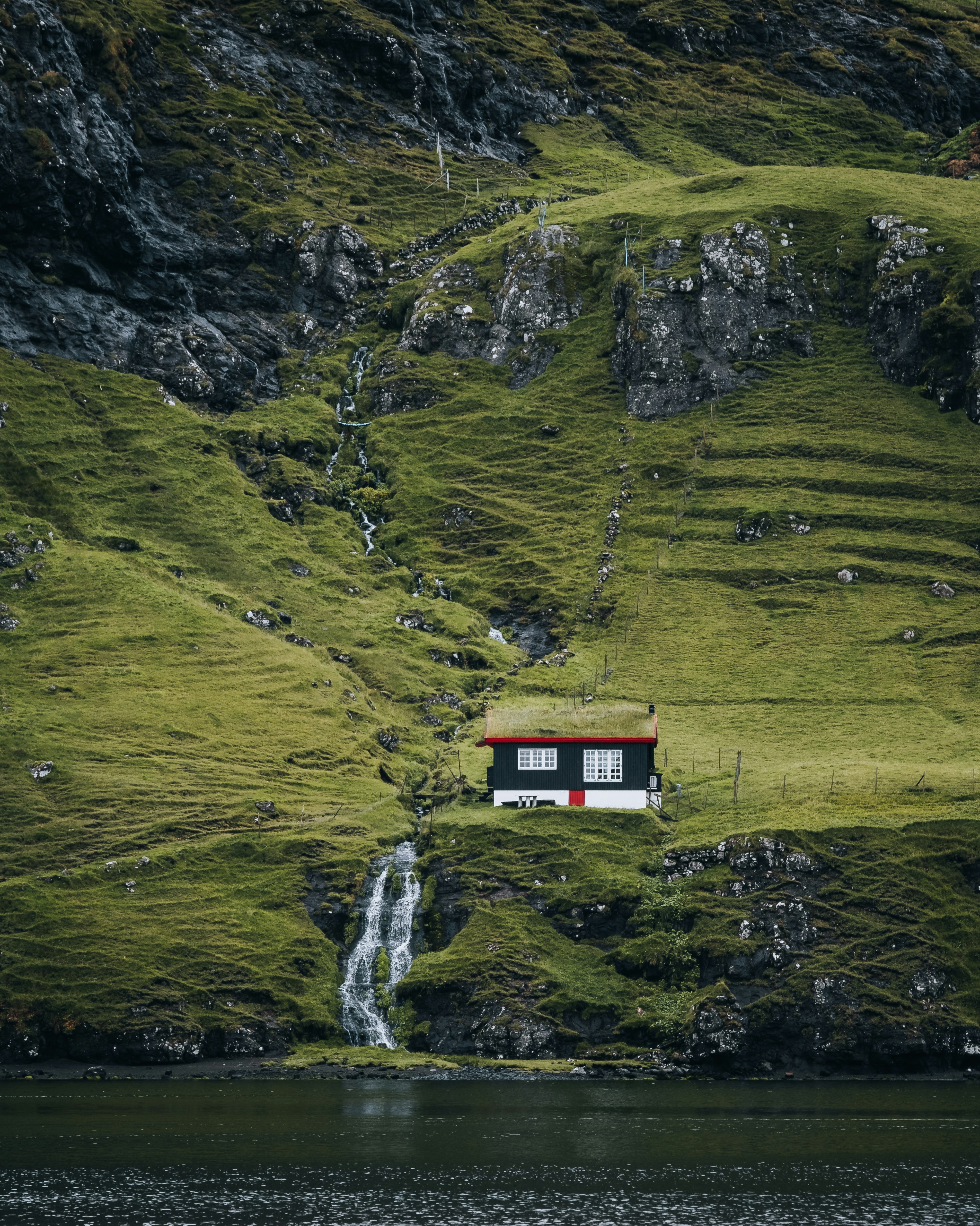 Cottage Clasped by Emerald Hills and a Veil of Waterfalls