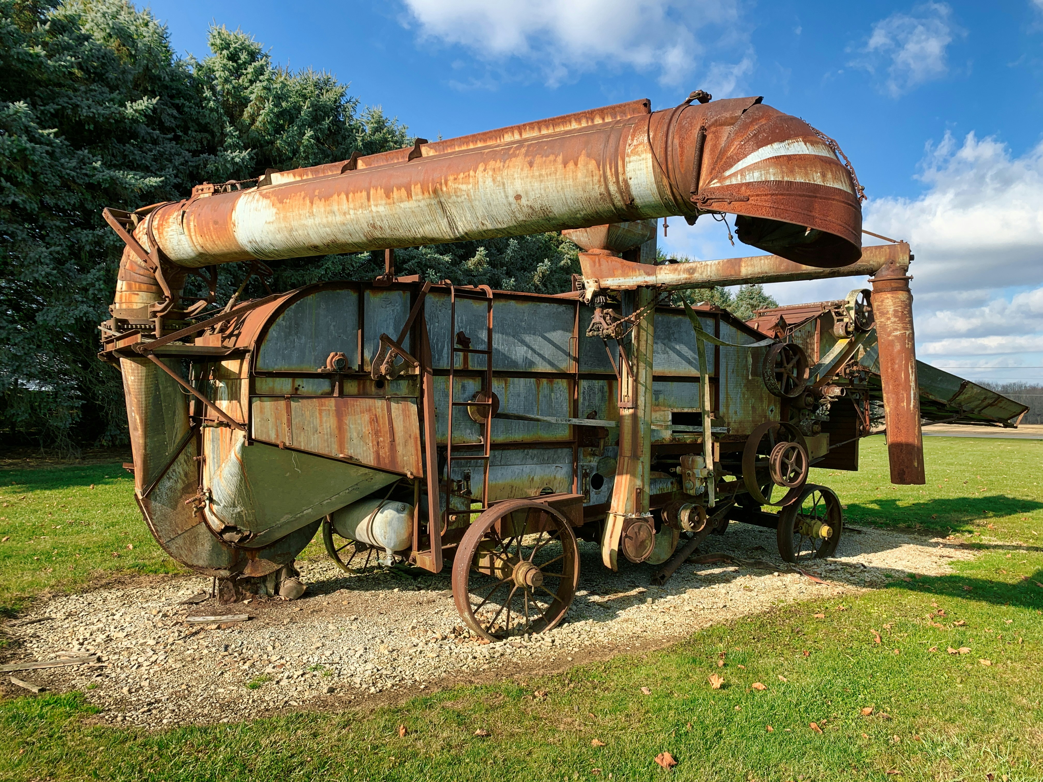 Rusted Goliath on the Field: A relic threshing engine under a bright sky