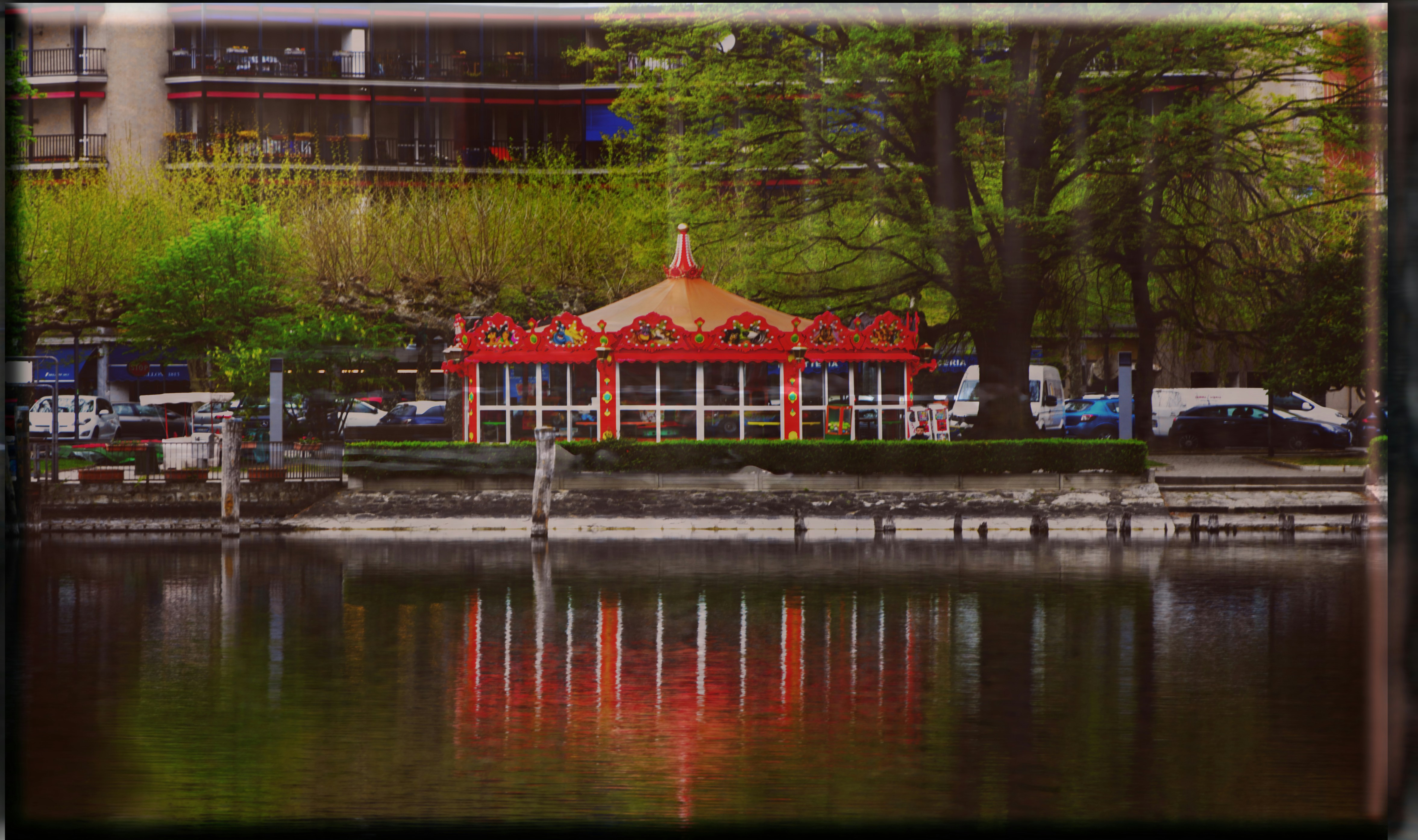 Red Carousel by the Water: a Riverside Orchard of Reflections