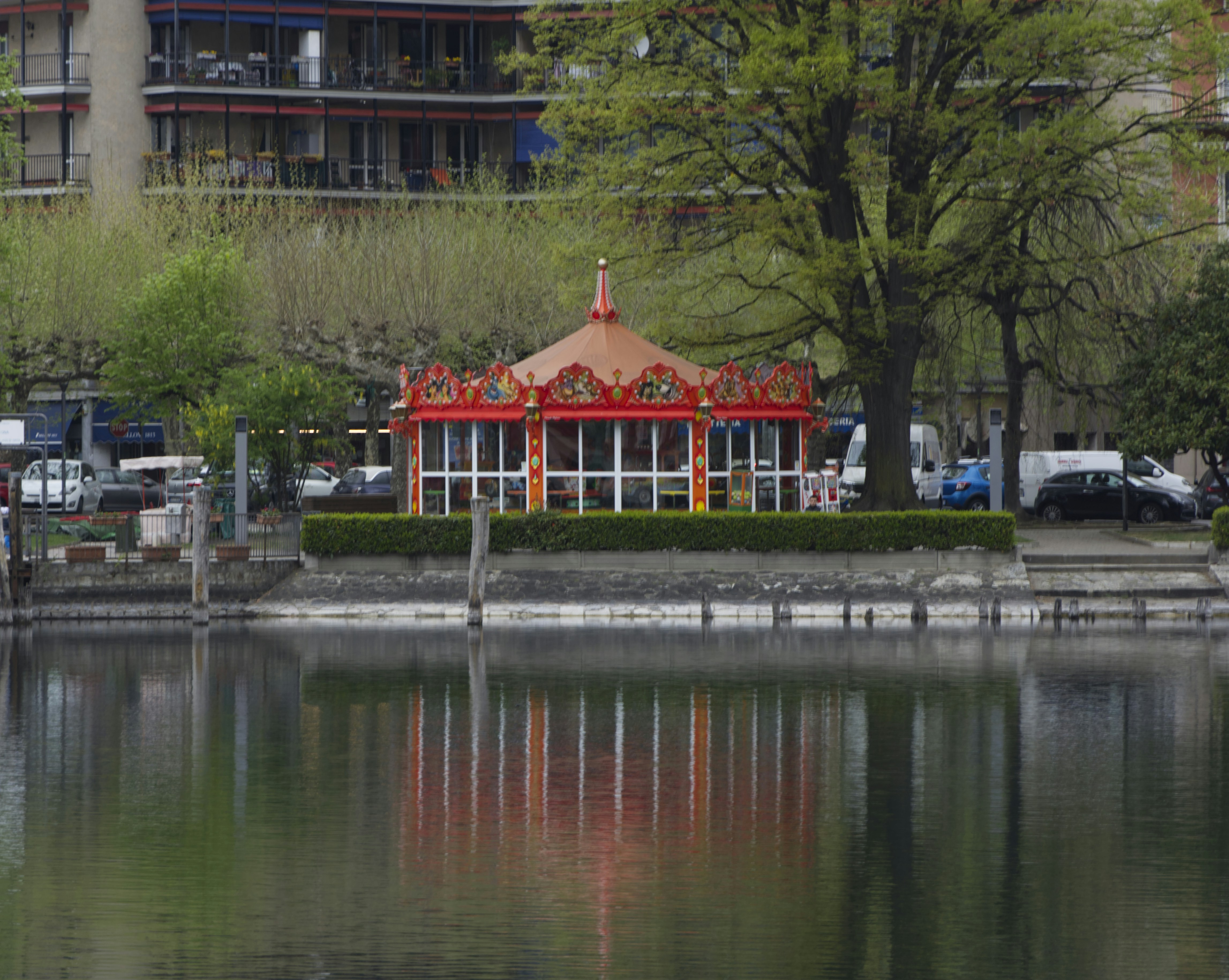 a building with a red roof by a body of water
