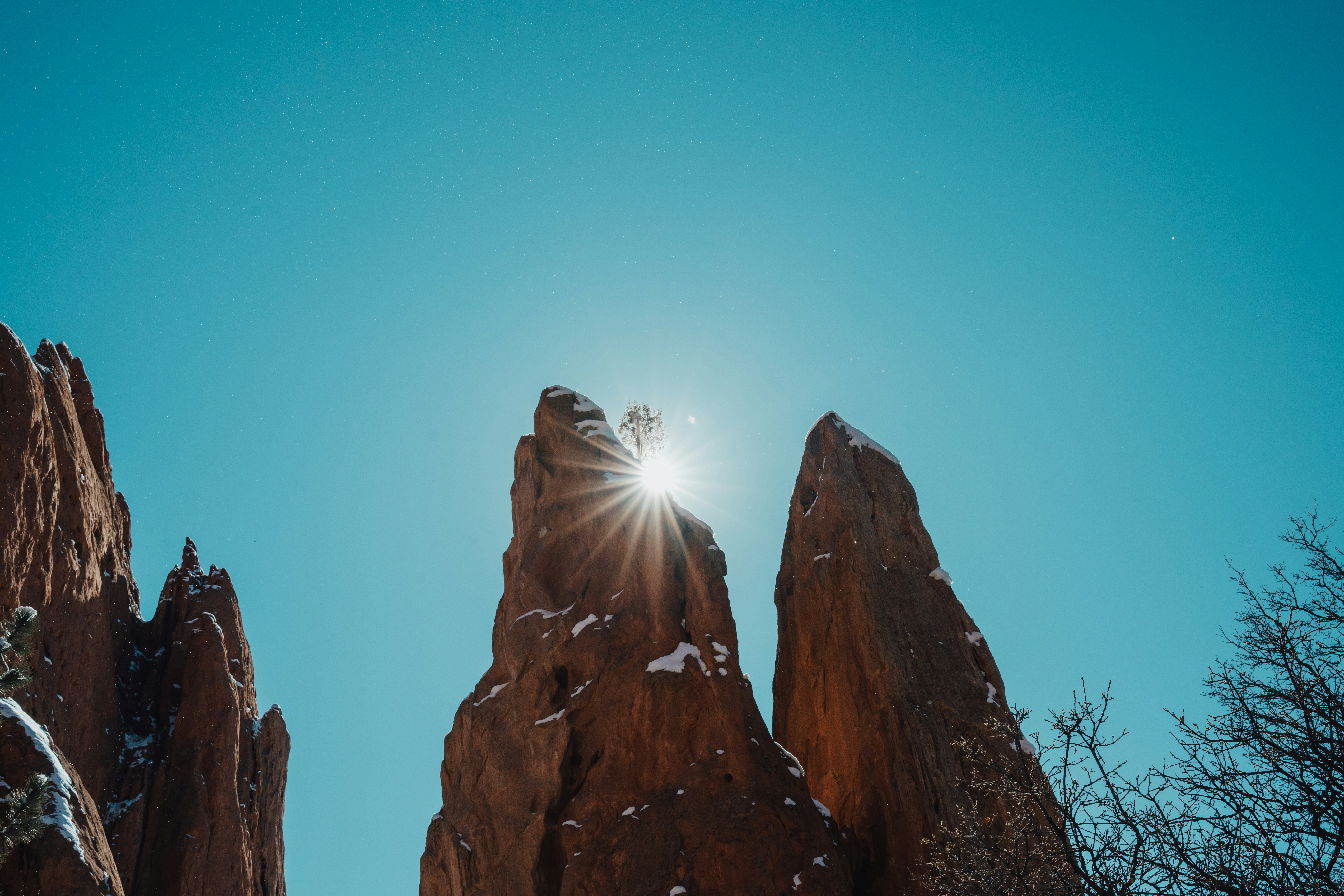 Sunburst on the Peak: A Snow-dusted Summit Against a Cobalt Sky