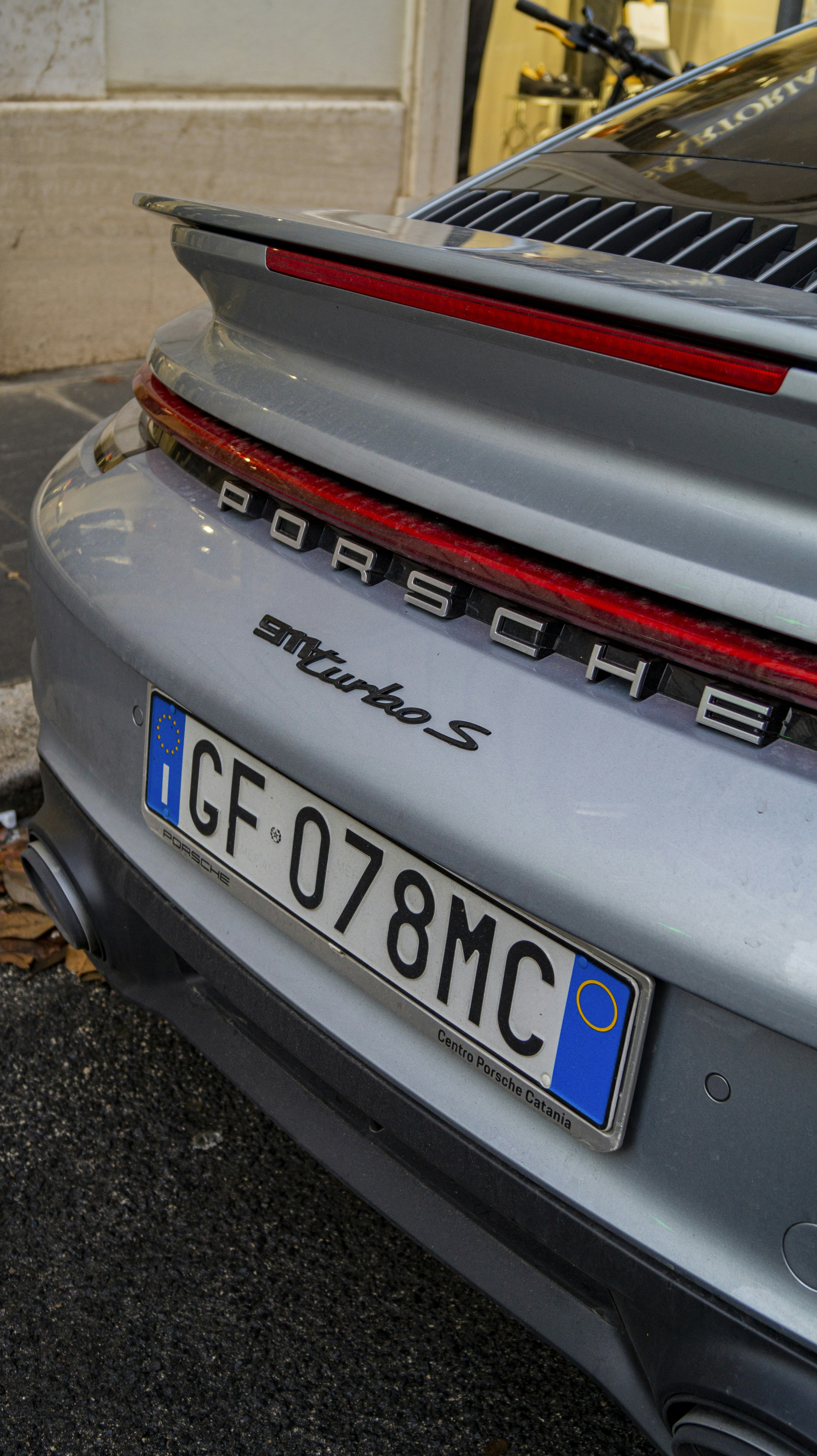 Rear view of a Porsche 911 Turbo S showcasing its sleek design and distinctive branding. The image captures the essence of automotive luxury.