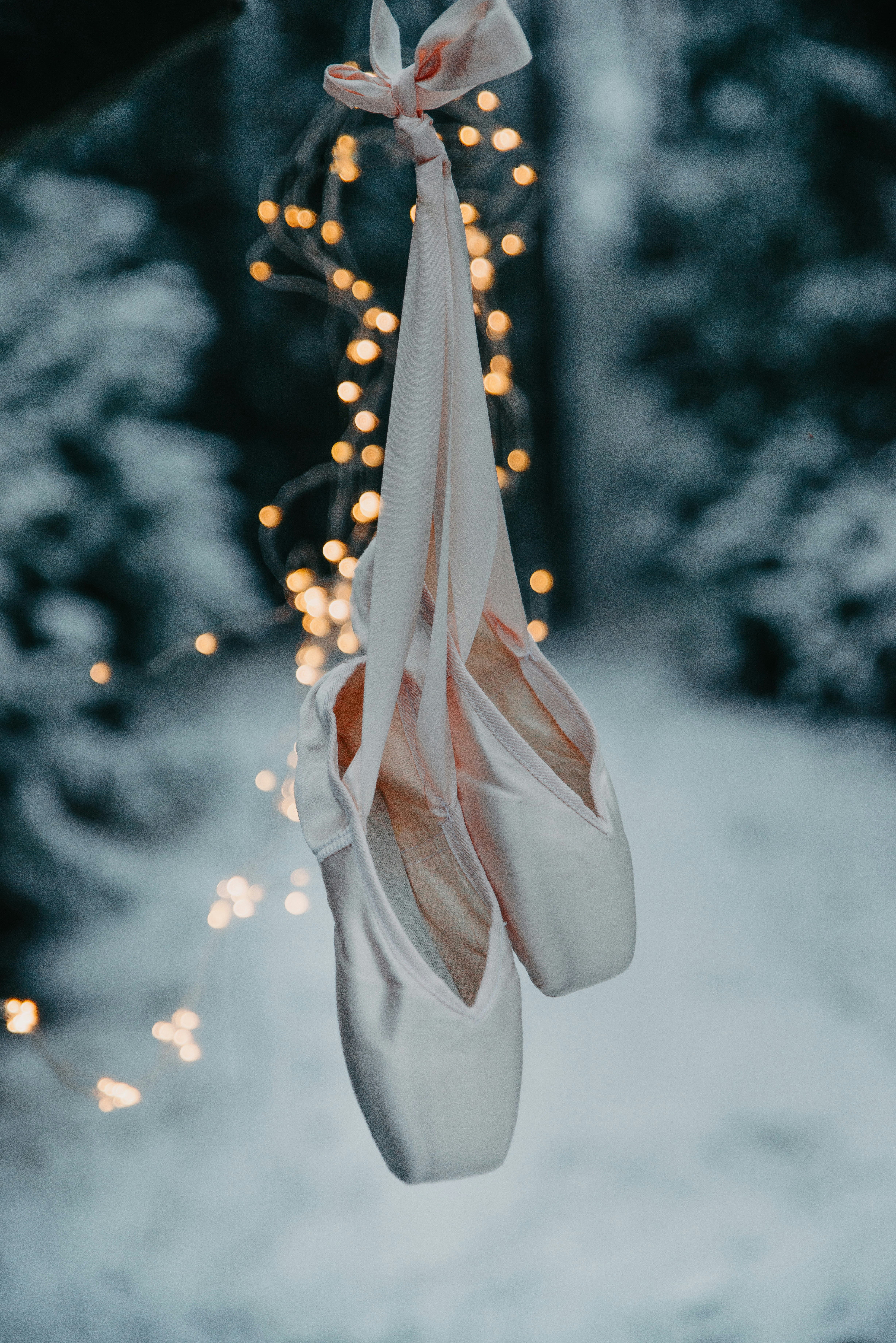 Hanging in Snow: Ballet Pointe Shoes Beneath Warm Fairy Lights