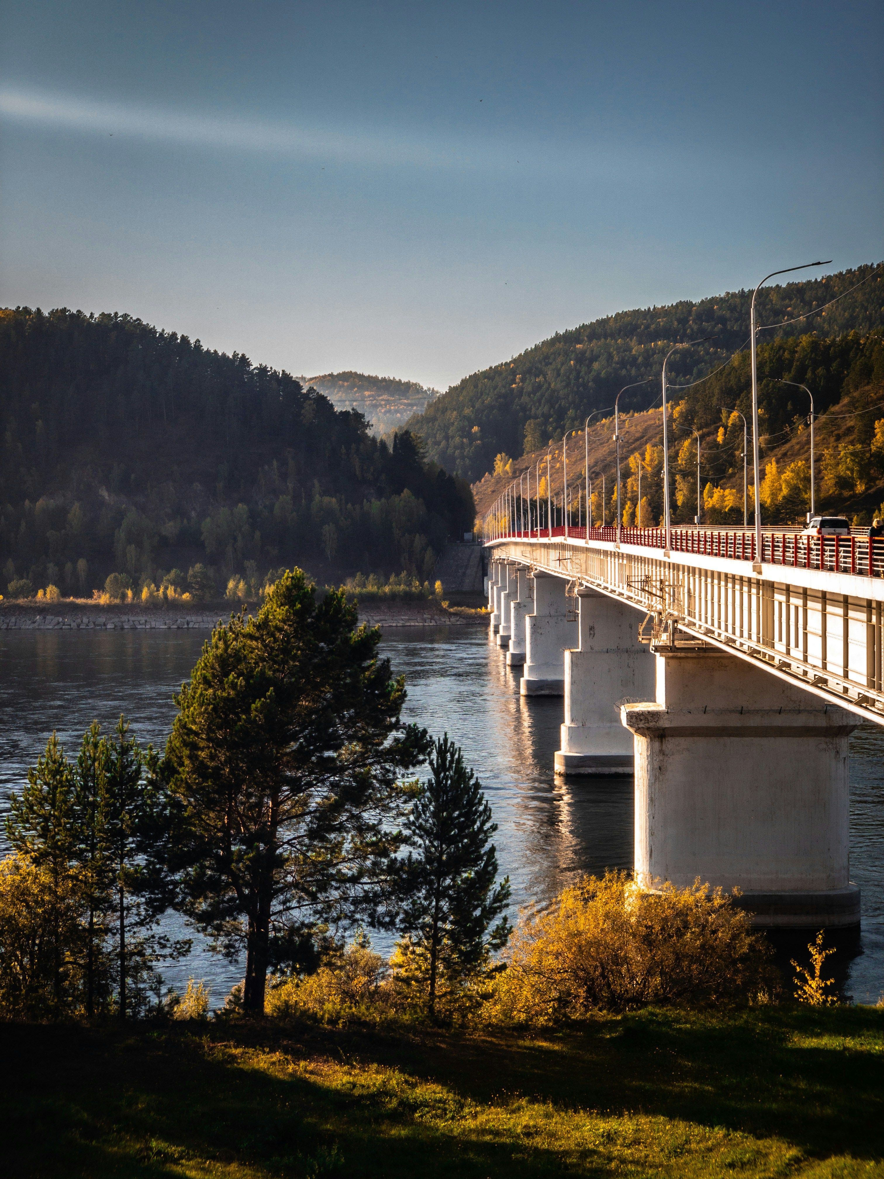 Sunlit Span: Autumn Bridge Crossing the Quiet River