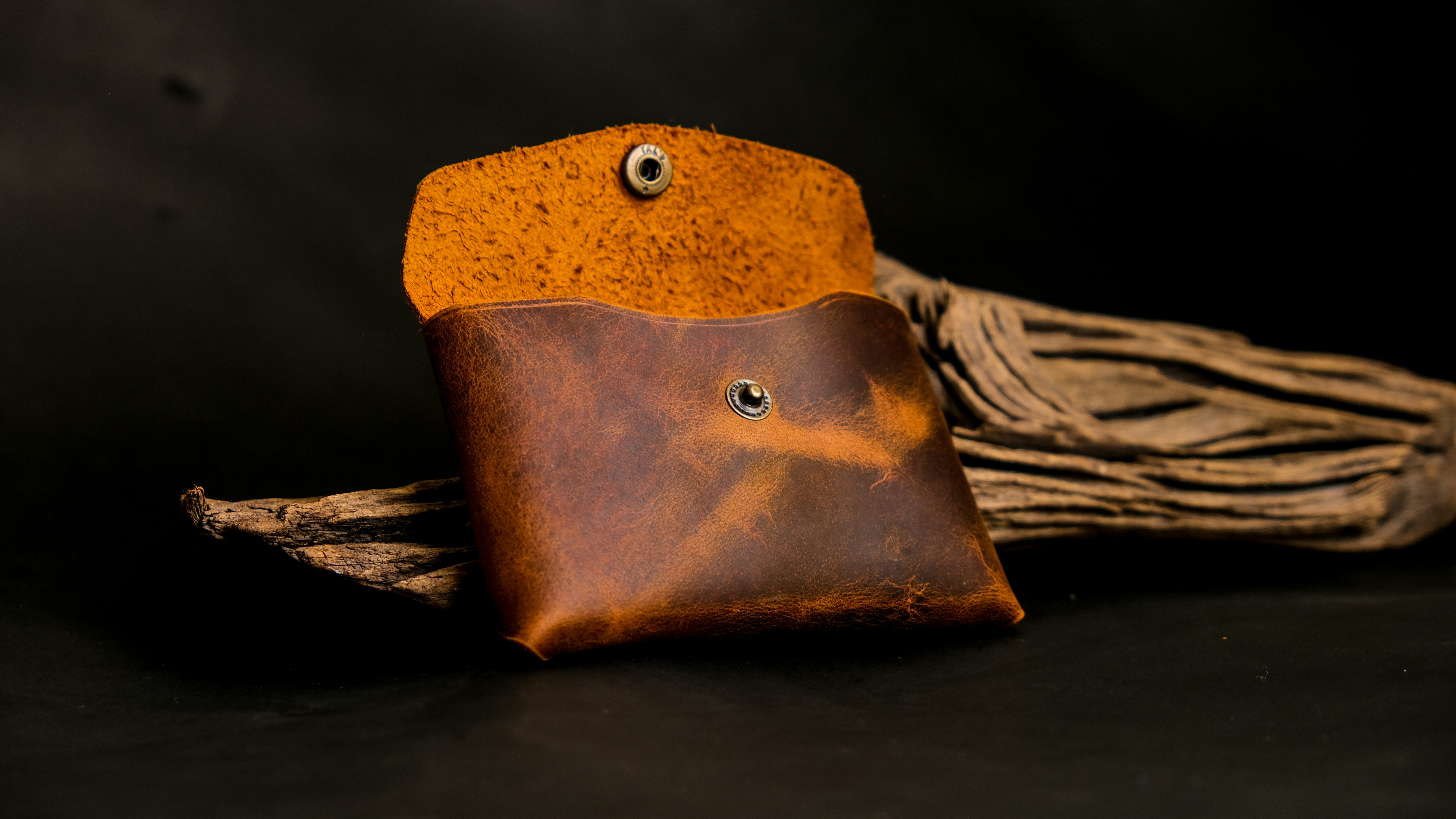 Patinaed Pouch on a Dark Stage: Quiet Study in Leather