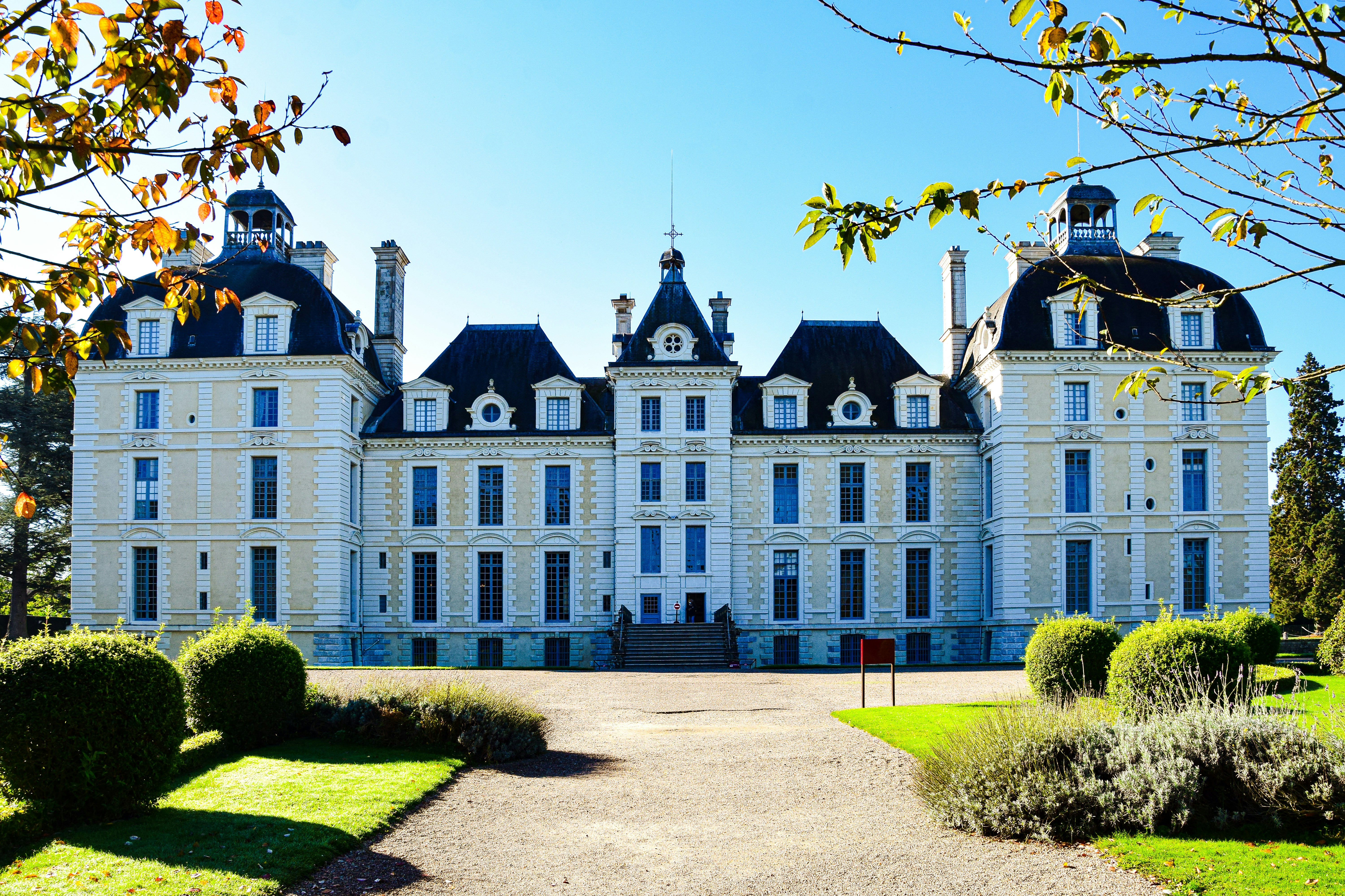 A large white building with a clock tower with Château de Cheverny in ...