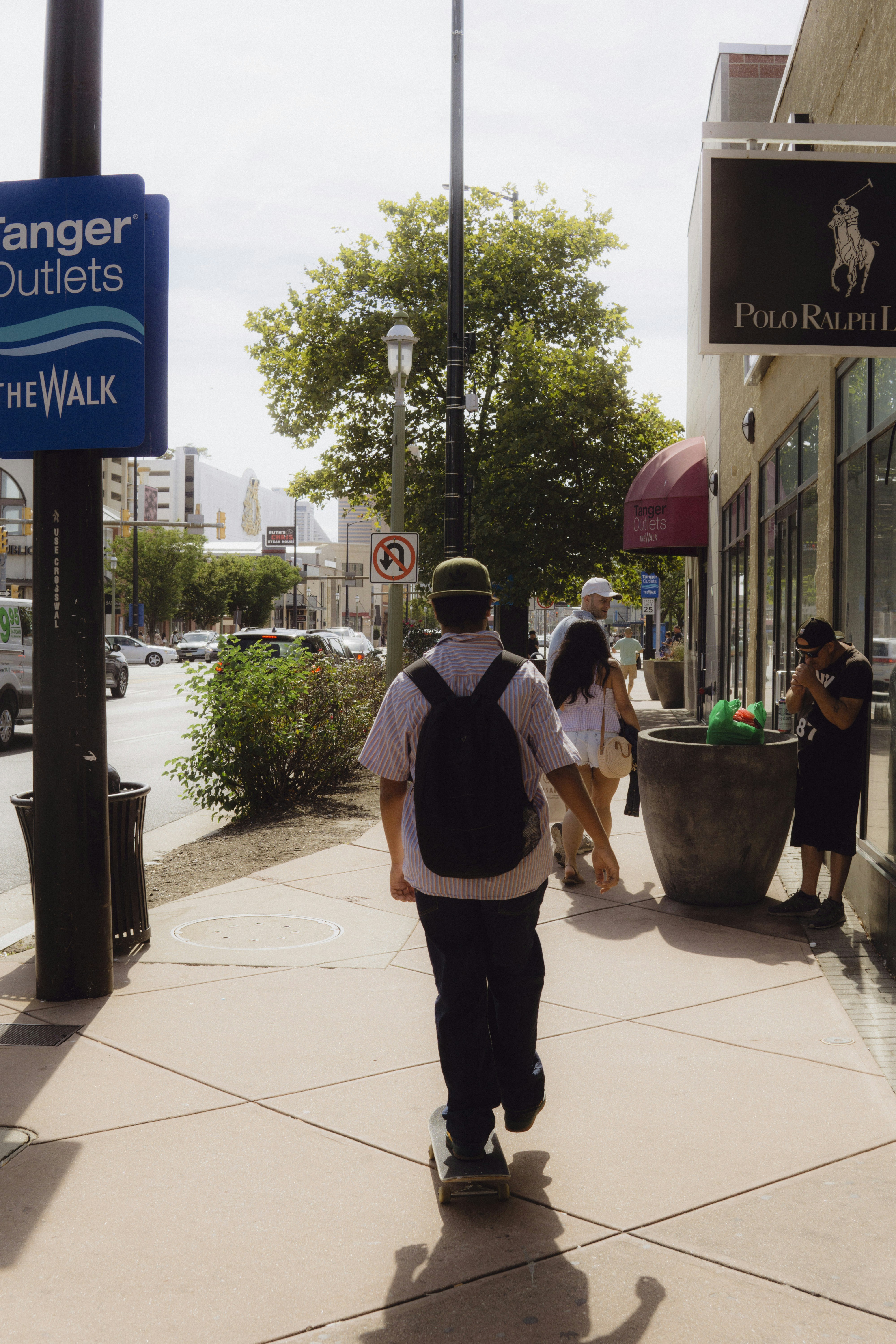 Backpack and Board: A Sunlit Walk Past Polo Ralph Lauren