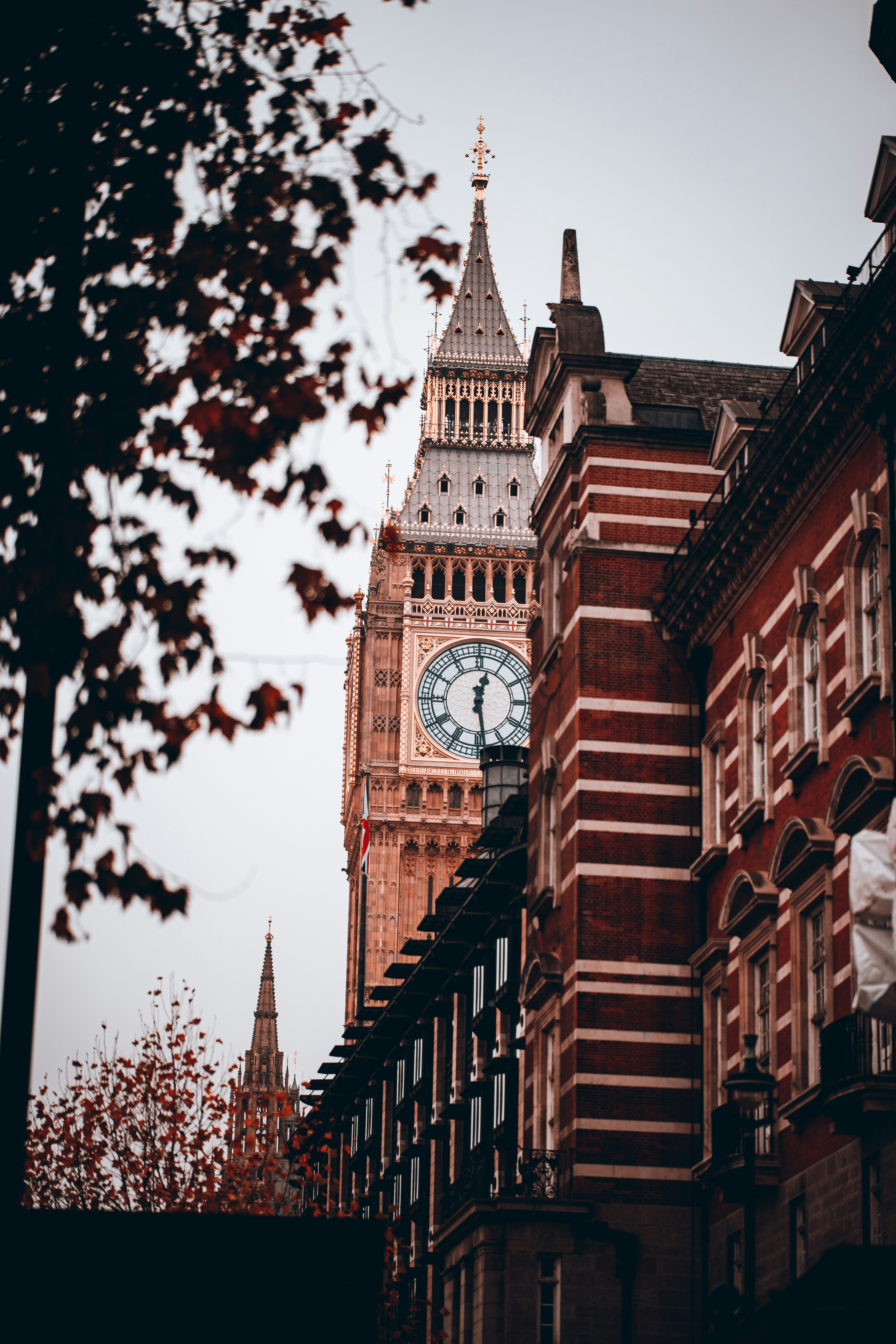 Timekeeper Among Red Brick: A London Street Portrait Framed by Autumn Leaves
