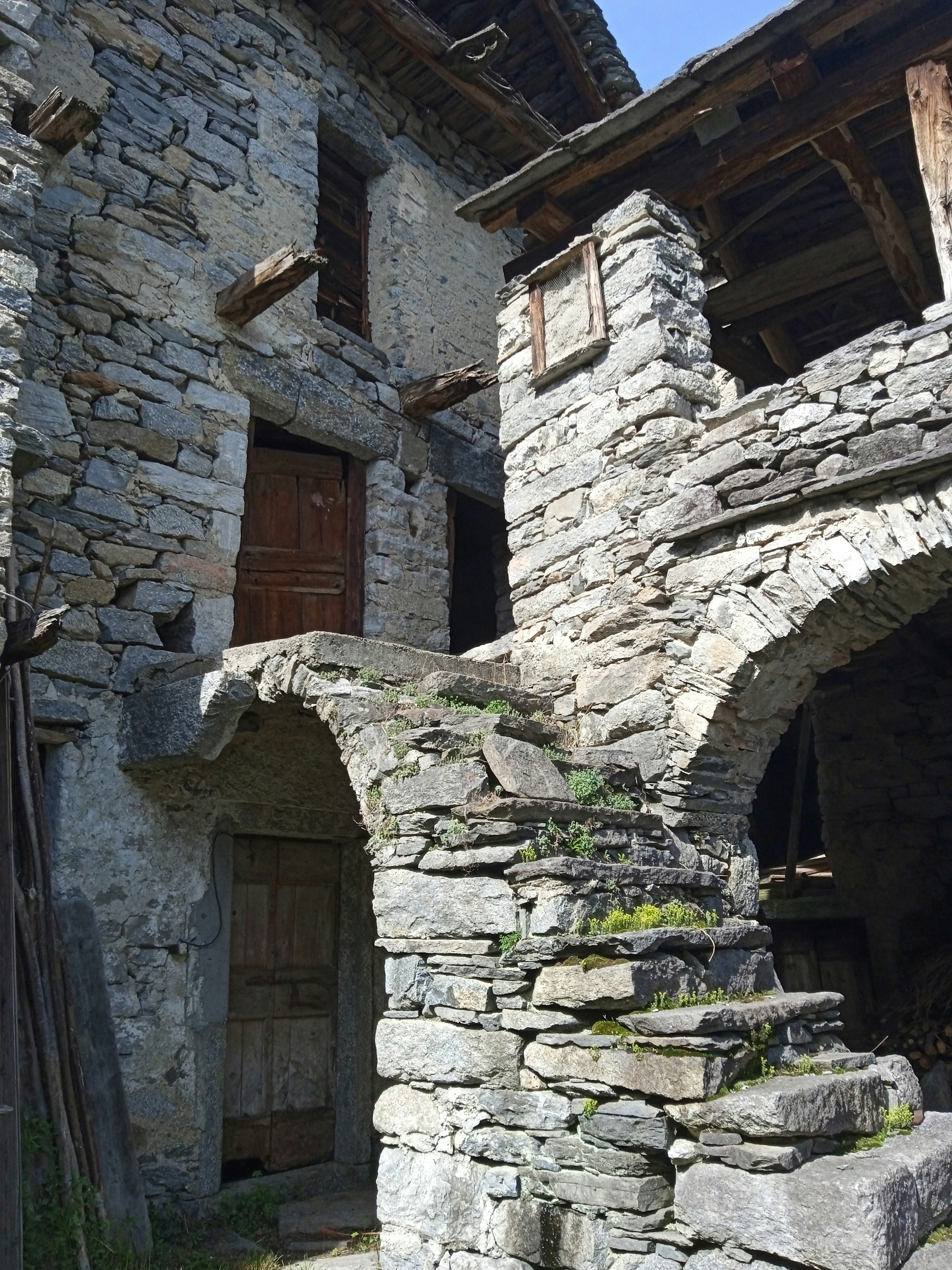 Weathered stone steps lead to a rustic doorway in an ancient structure, showcasing the charm of bygone architecture.