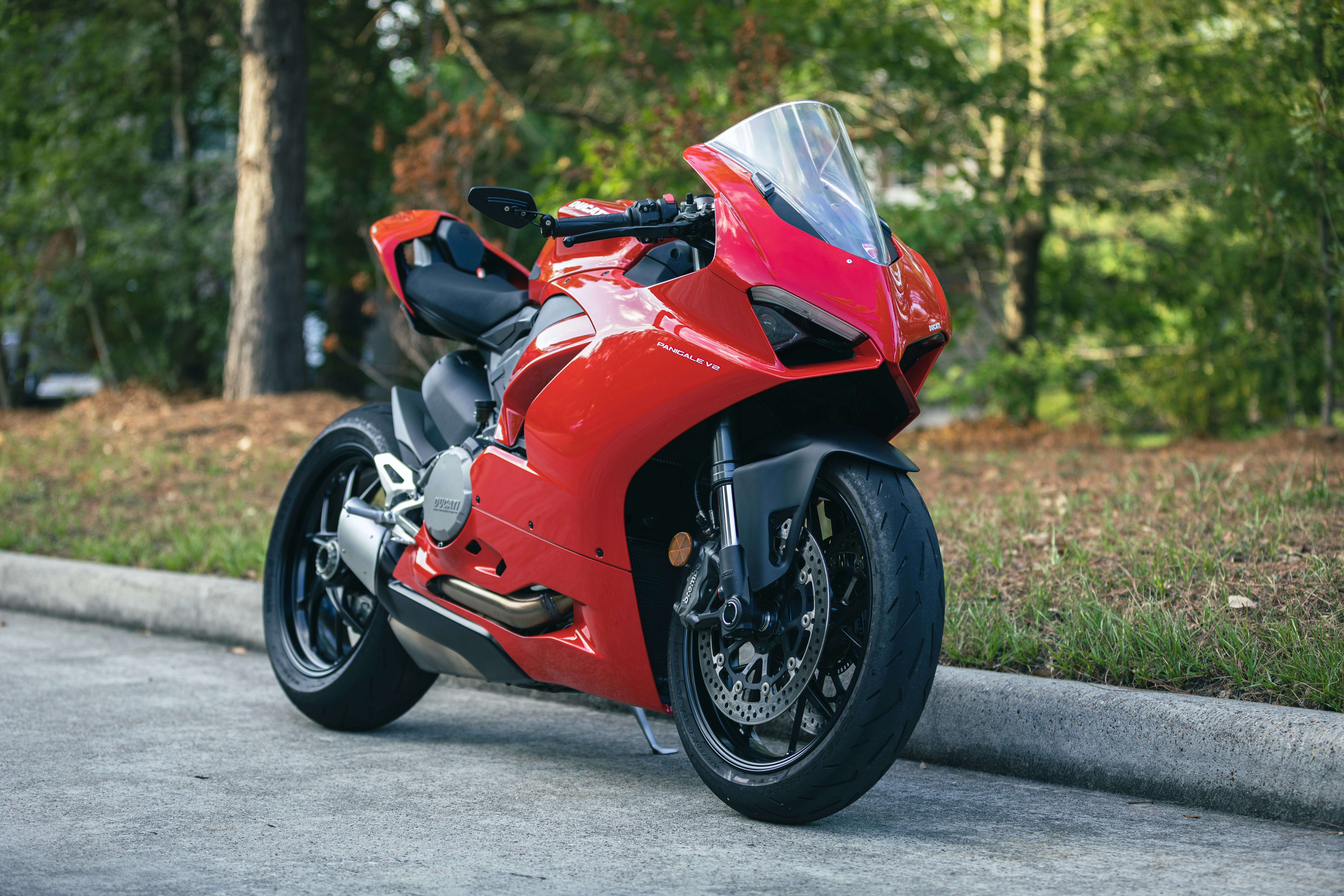 Foto Una motocicleta roja estacionada al costado de una carretera ...