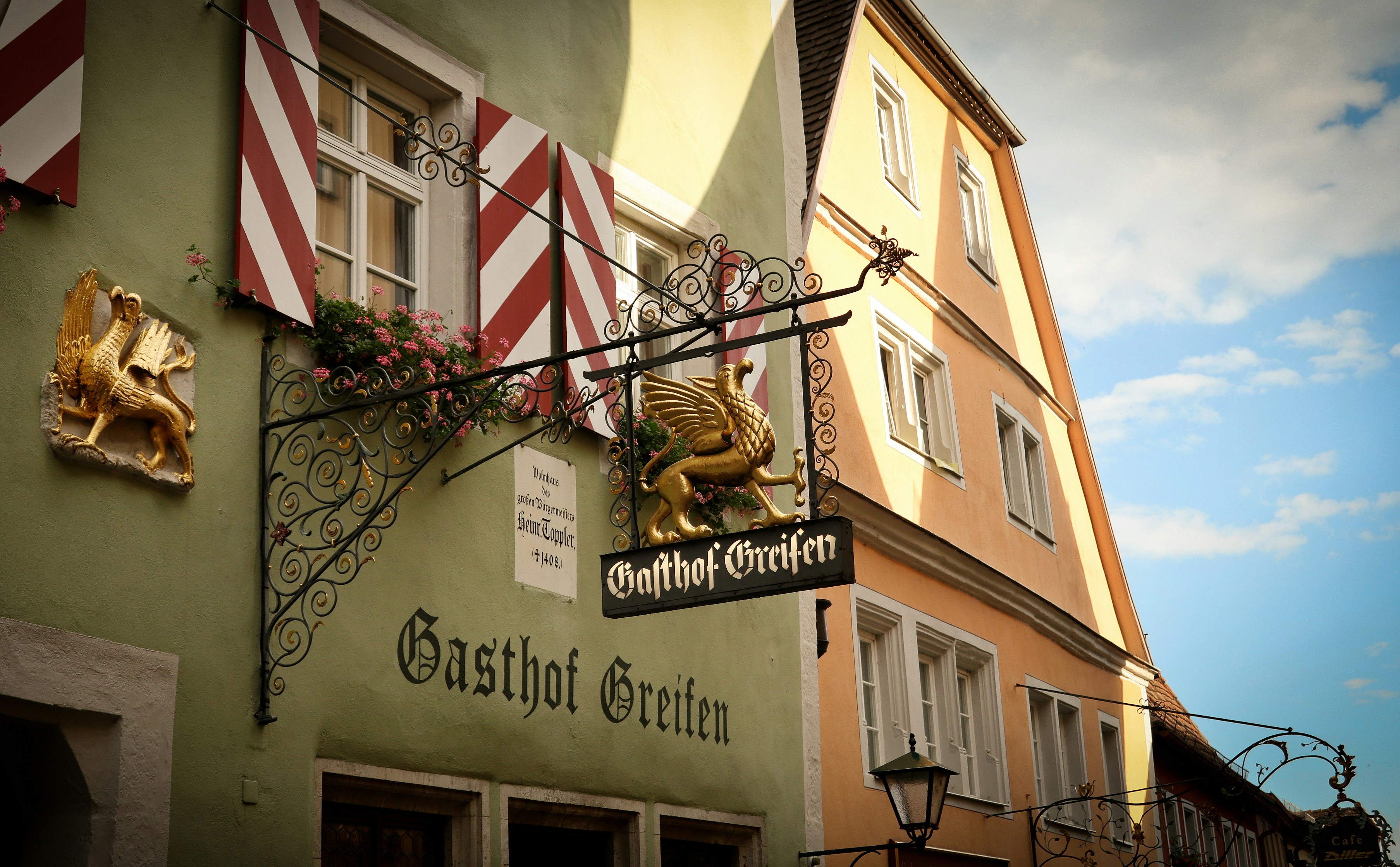 Griffin-Guarded Gasthof Sign on a Sunlit Bavarian Street