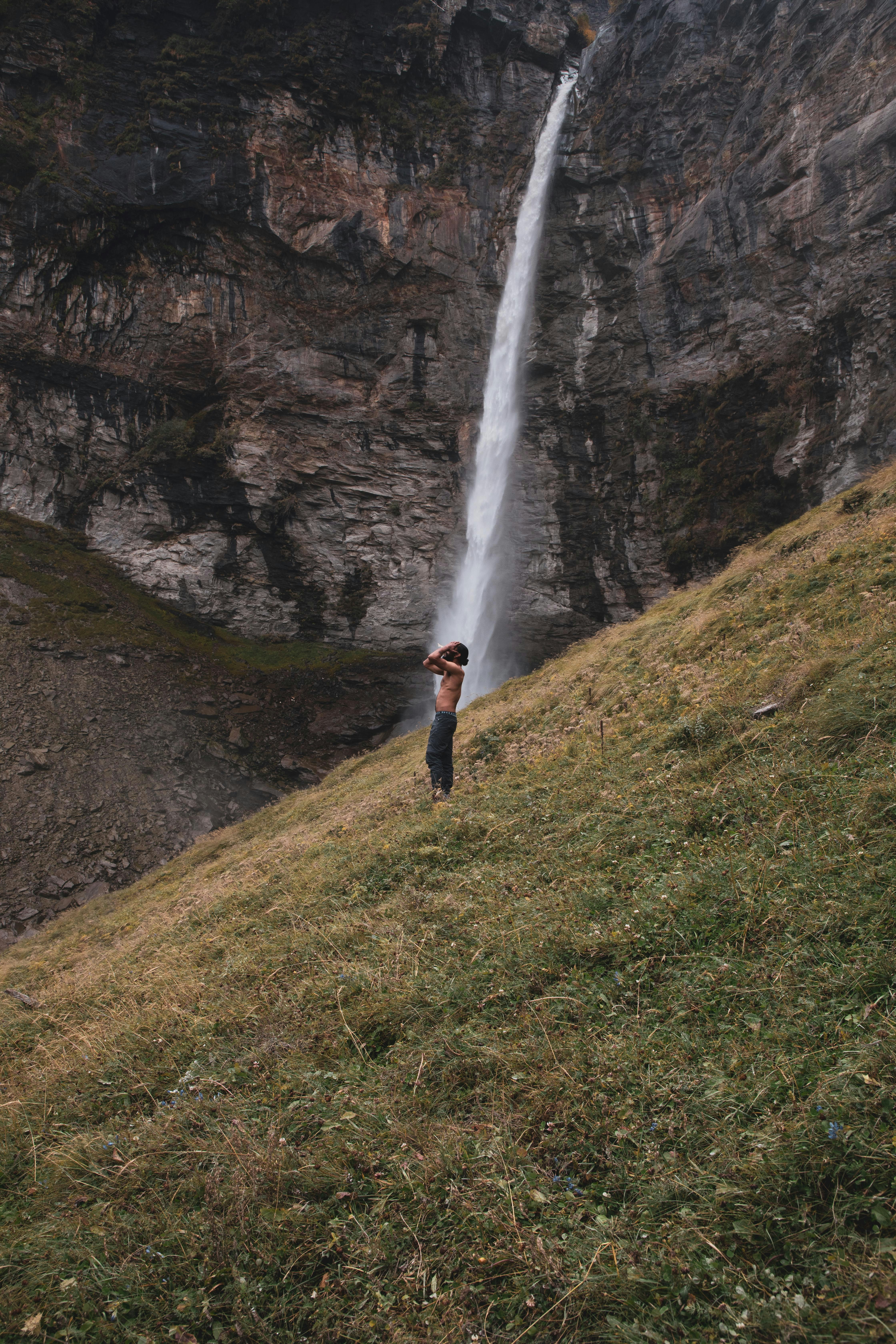 Une personne debout devant une cascade photo – Photo Pente Gratuite sur ...