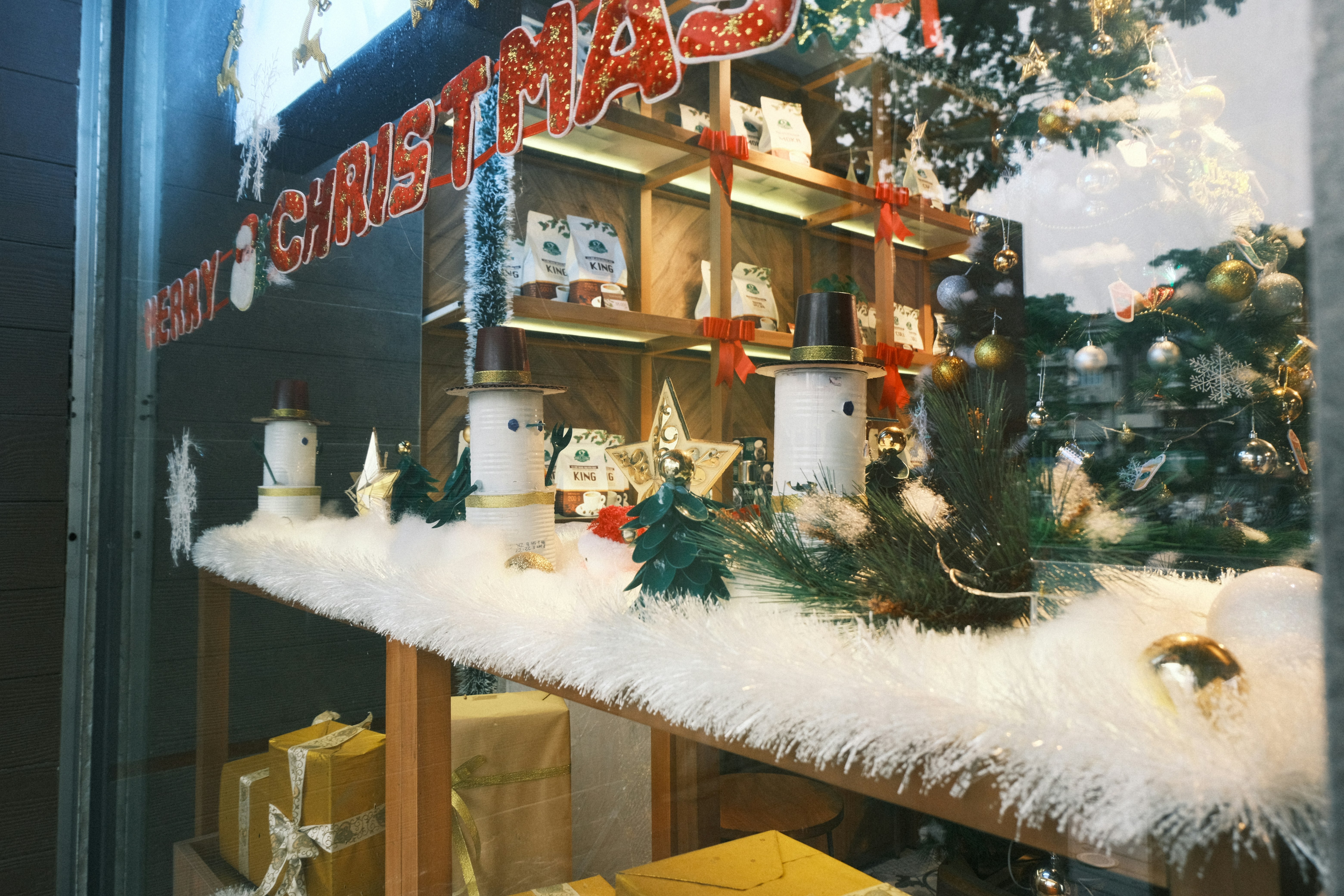 Snow-Laced Shop Window: Lanterns and Tiny Trees in a Holiday Display
