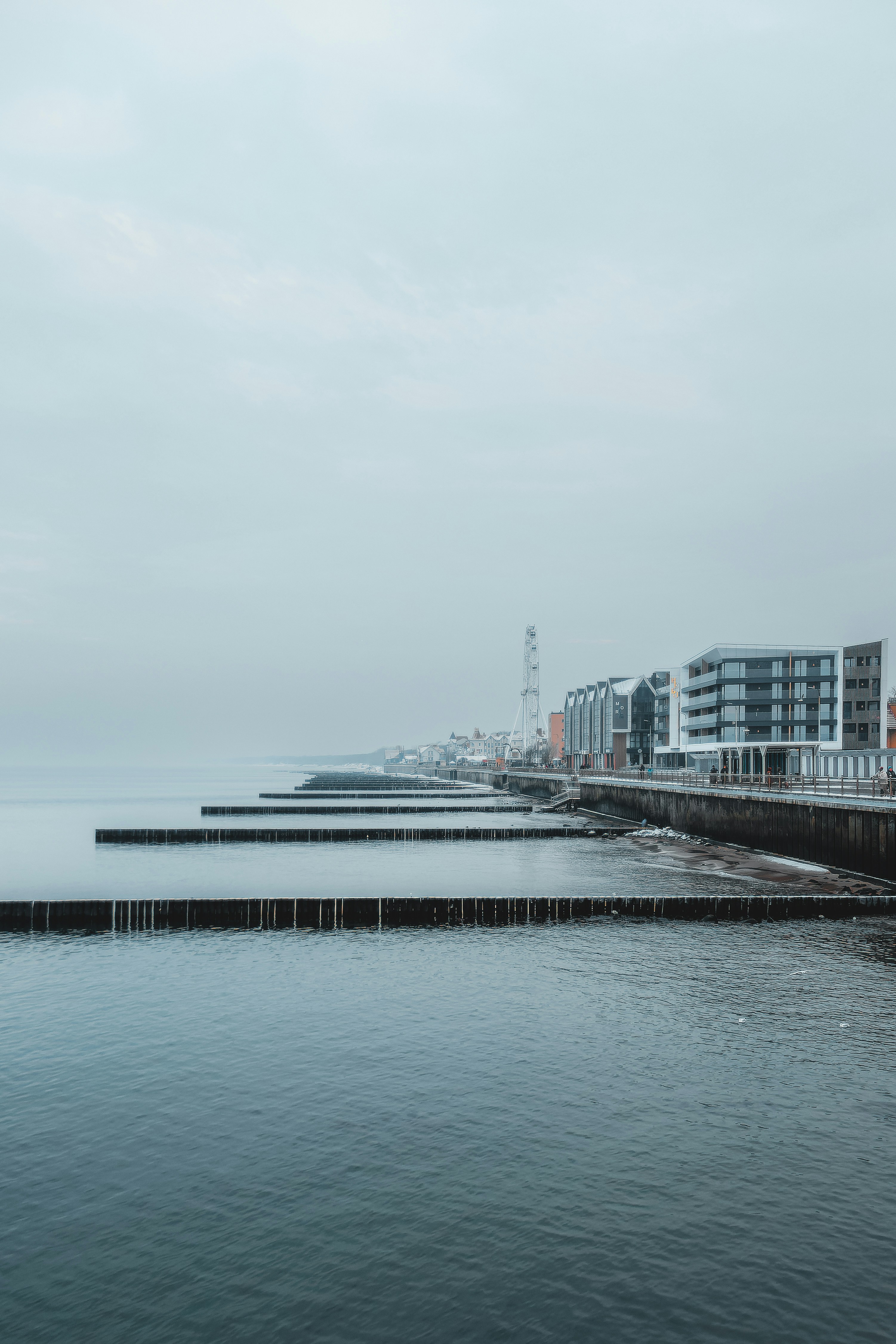 Powder-Blue Waterfront: A Pier Extends Toward the Distant Horizon
