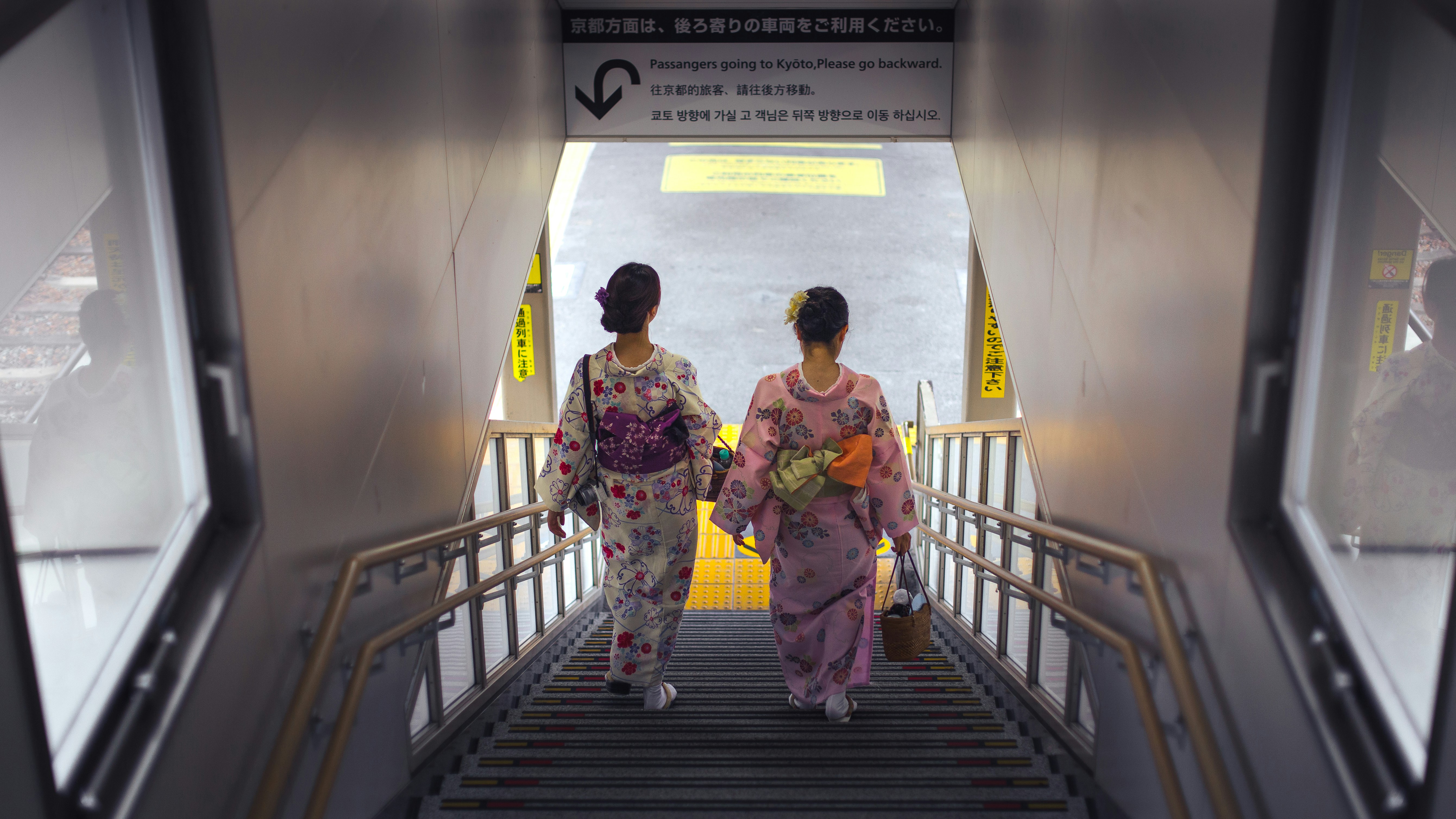 Kimono Rewind: Two Women Descend the Stairs from a Train Station