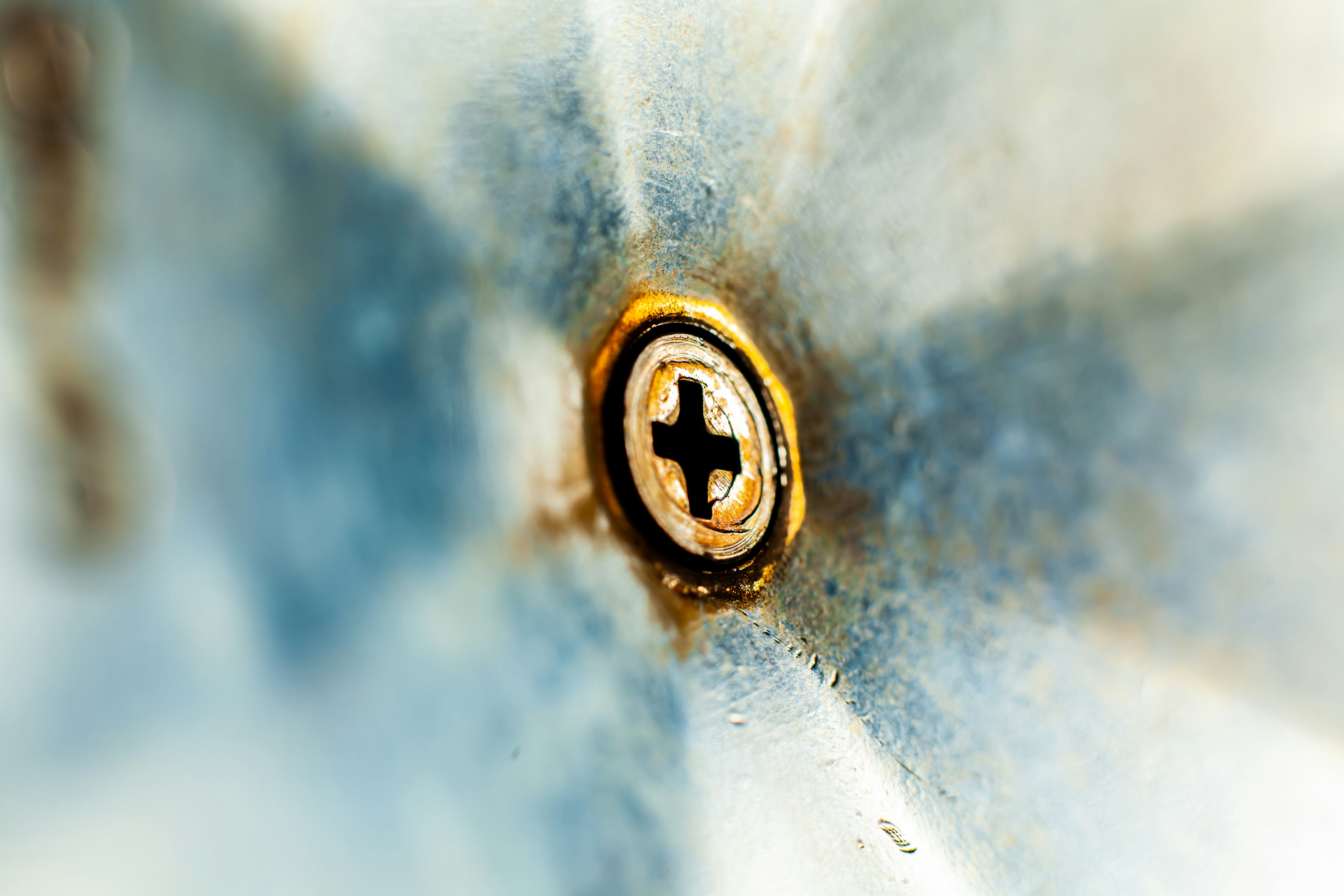 Blue-Rust Halo: Macro Portrait of a Weathered Screw in Painted Metal