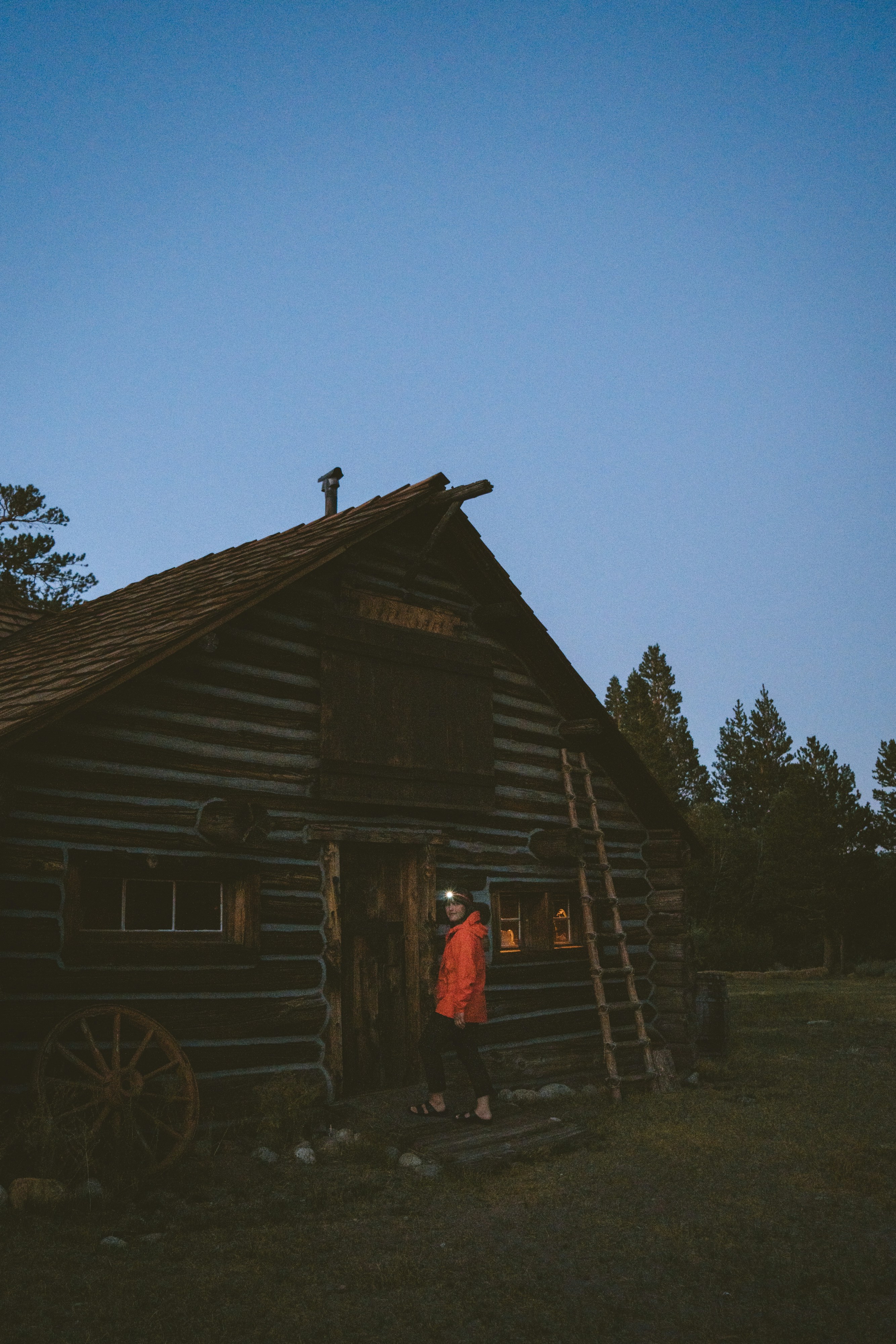 Red-Clad Moment at Blue Hour by a Rustic Log Cabin