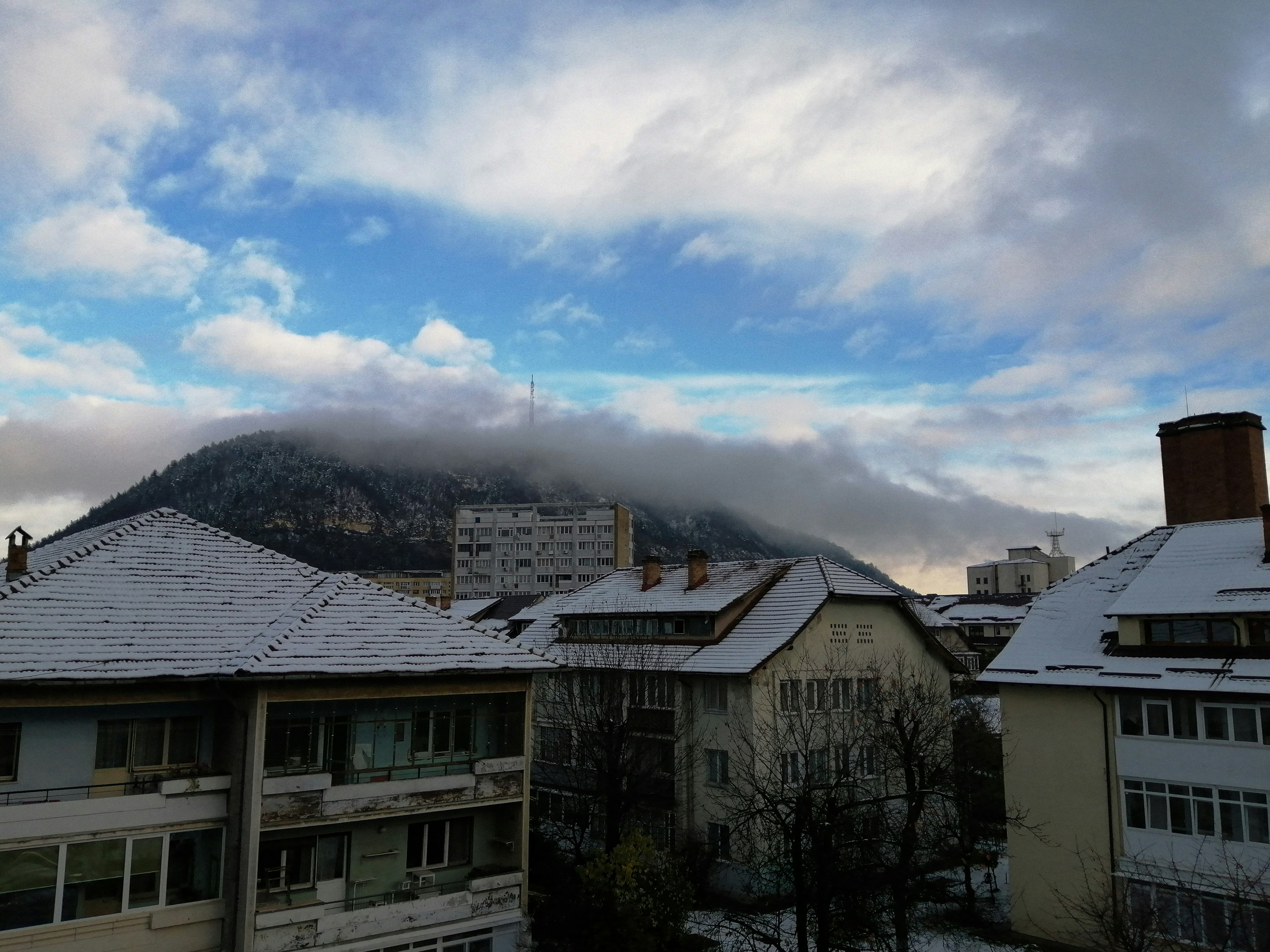 Snow-Capped Rooftops Under a Break in the Clouds