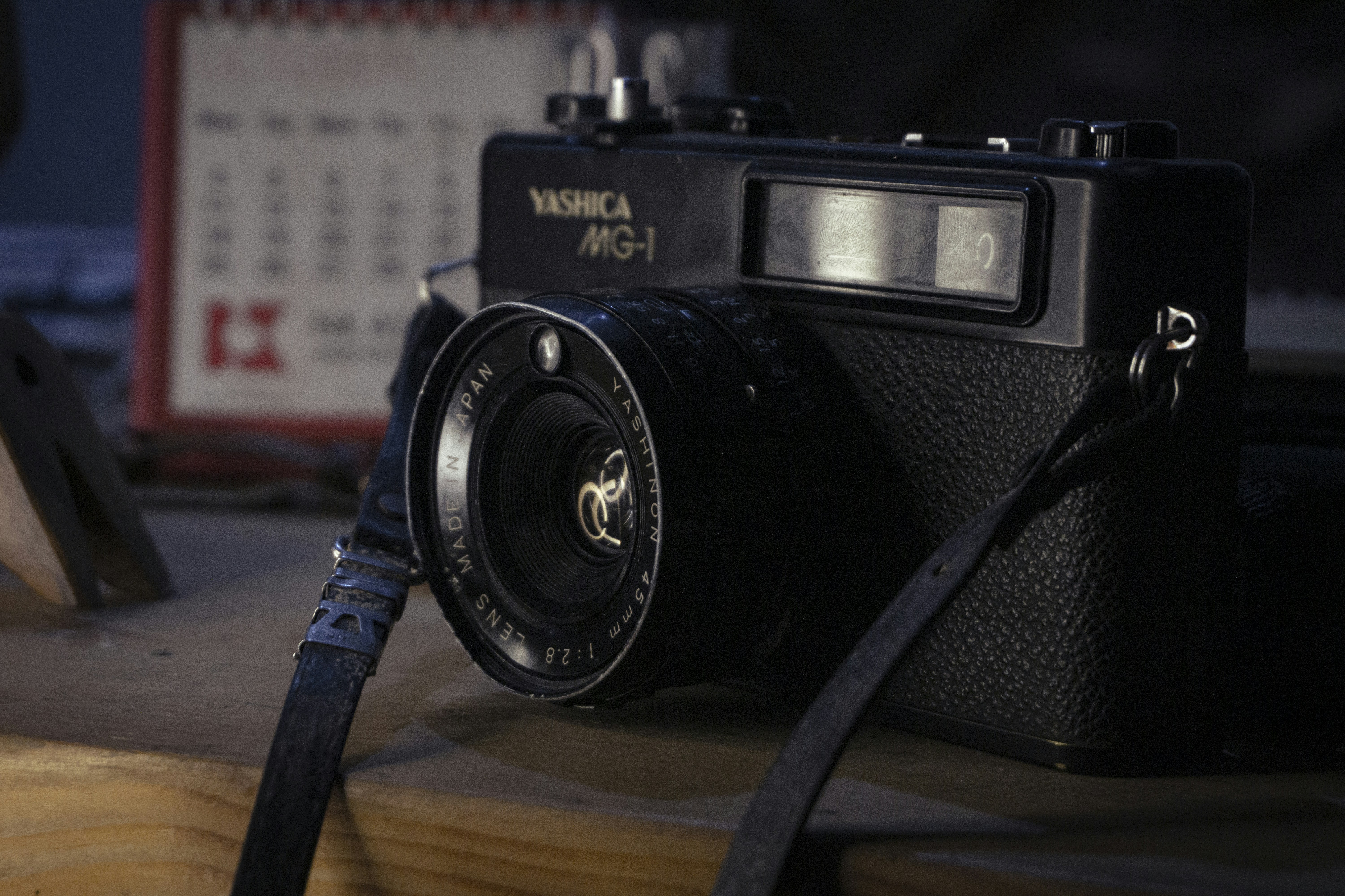 Midnight Lens: A Yashica MG-1 Resting on the Wooden Desk