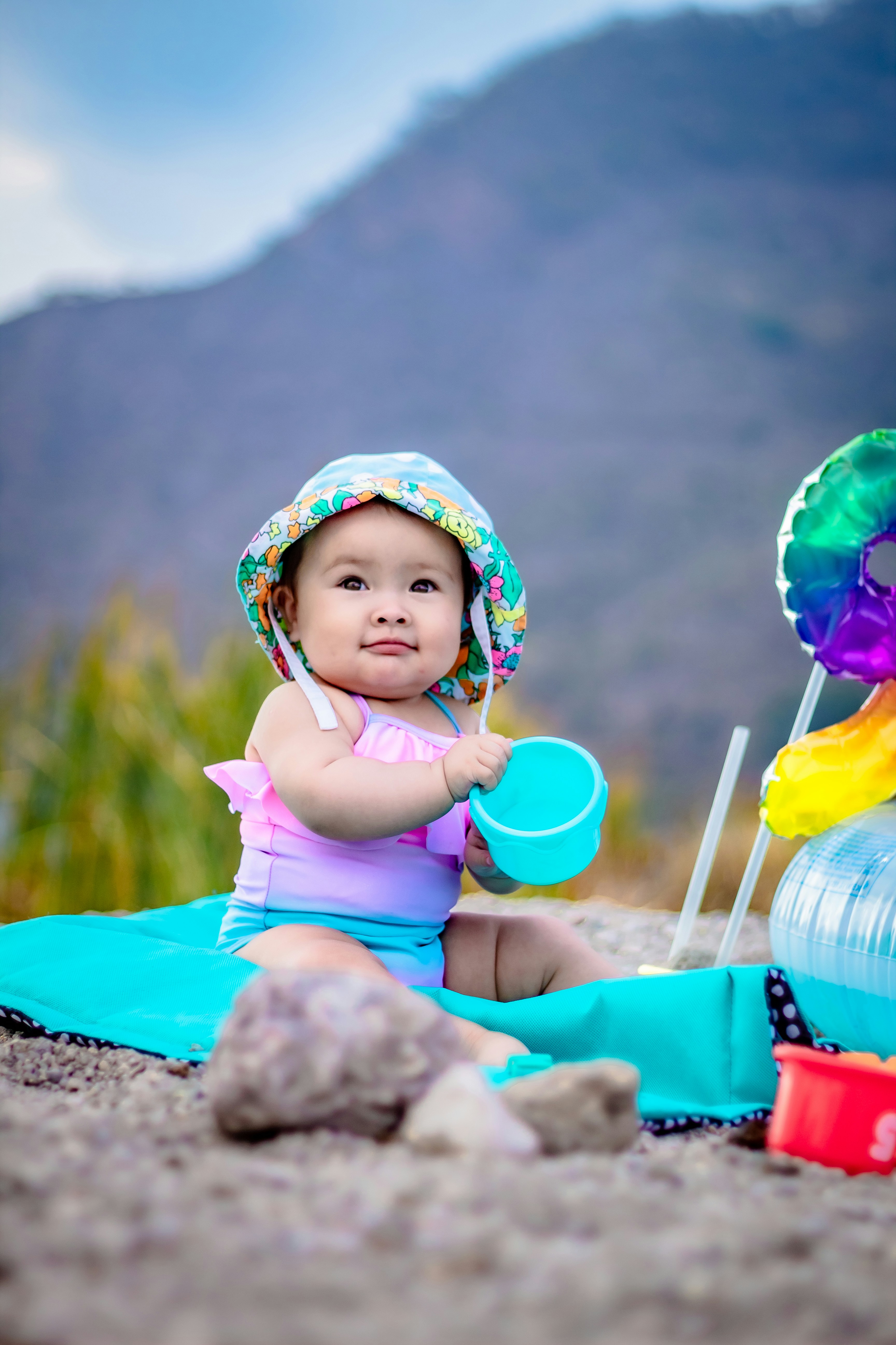 Beachside Baby in a Colorful Hat with Toy Buckets
