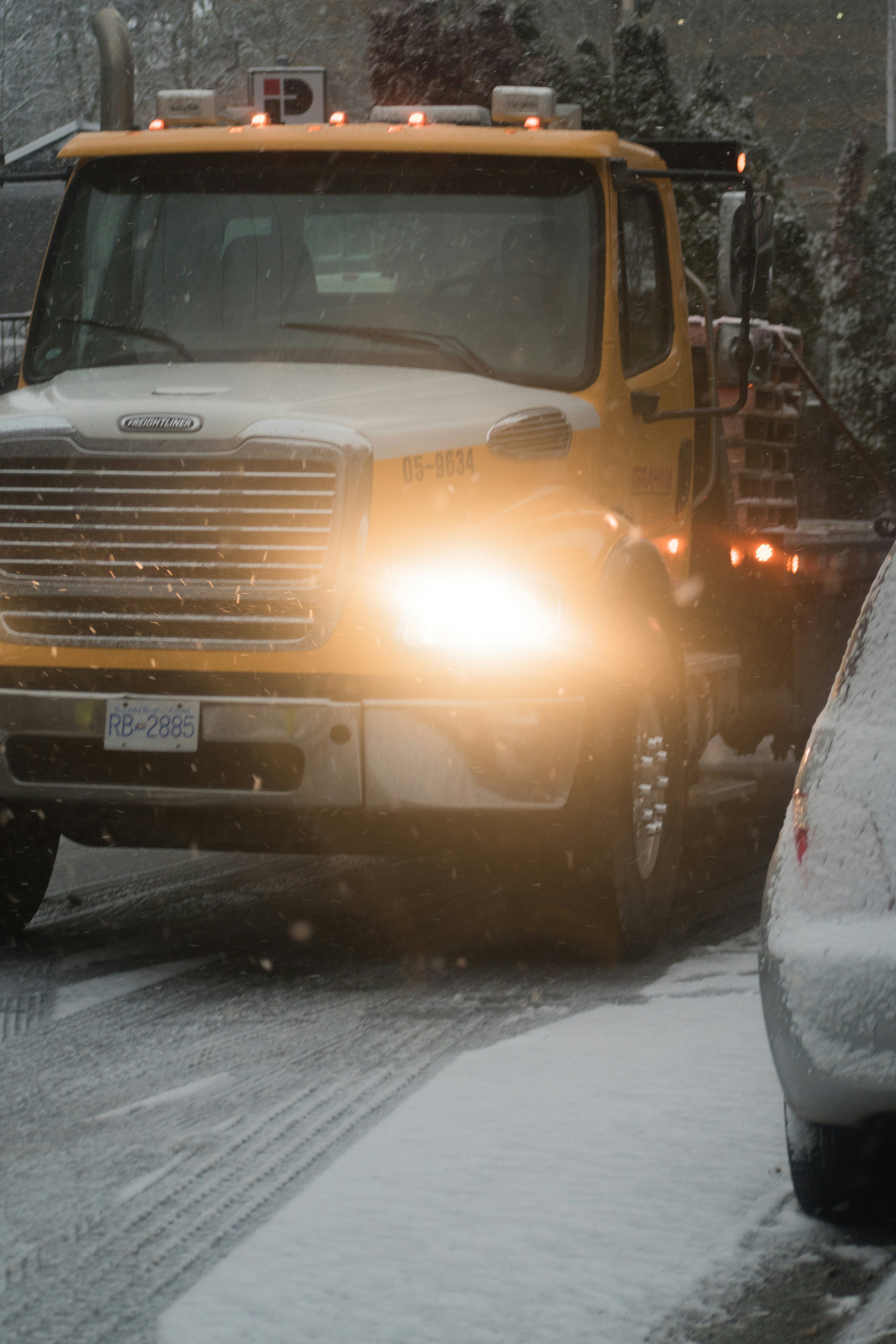 Snowbound Front-Runner: A Yellow Utility Truck Braving the Snowy Street