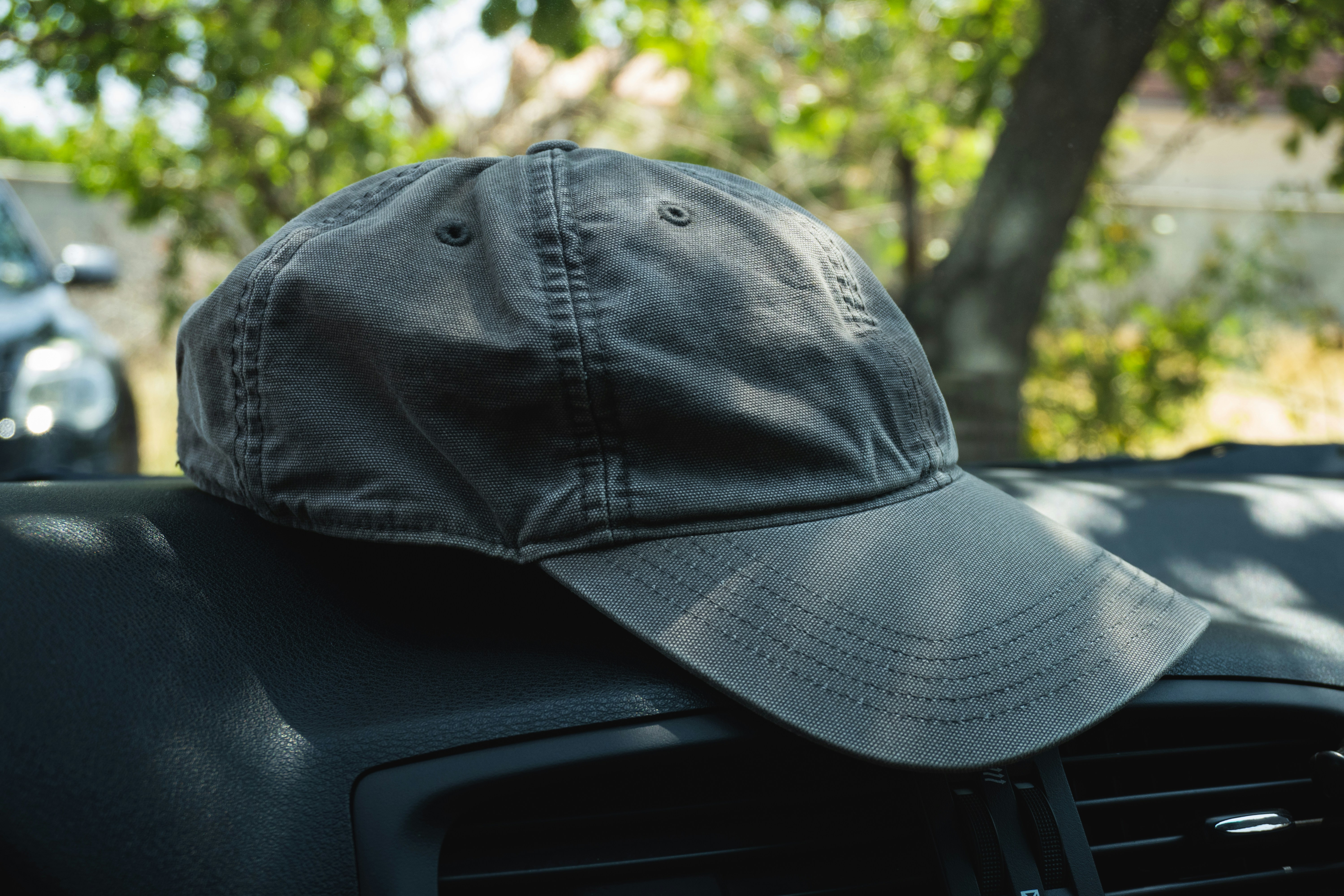 Grey Baseball Cap Reposes on a Car Dash Amid Quiet Daylight