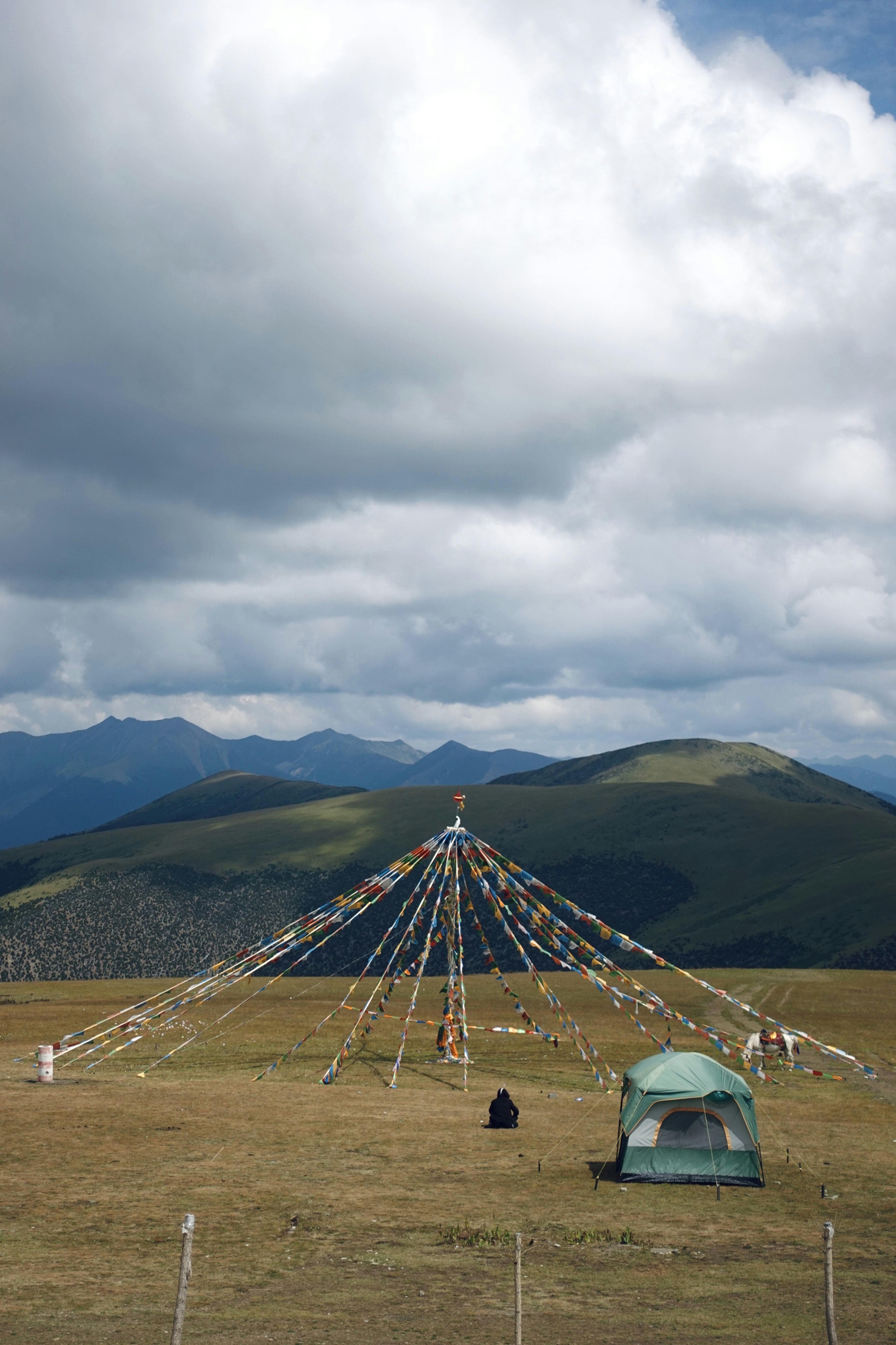 a tent and a tent in a field with mountains in the background