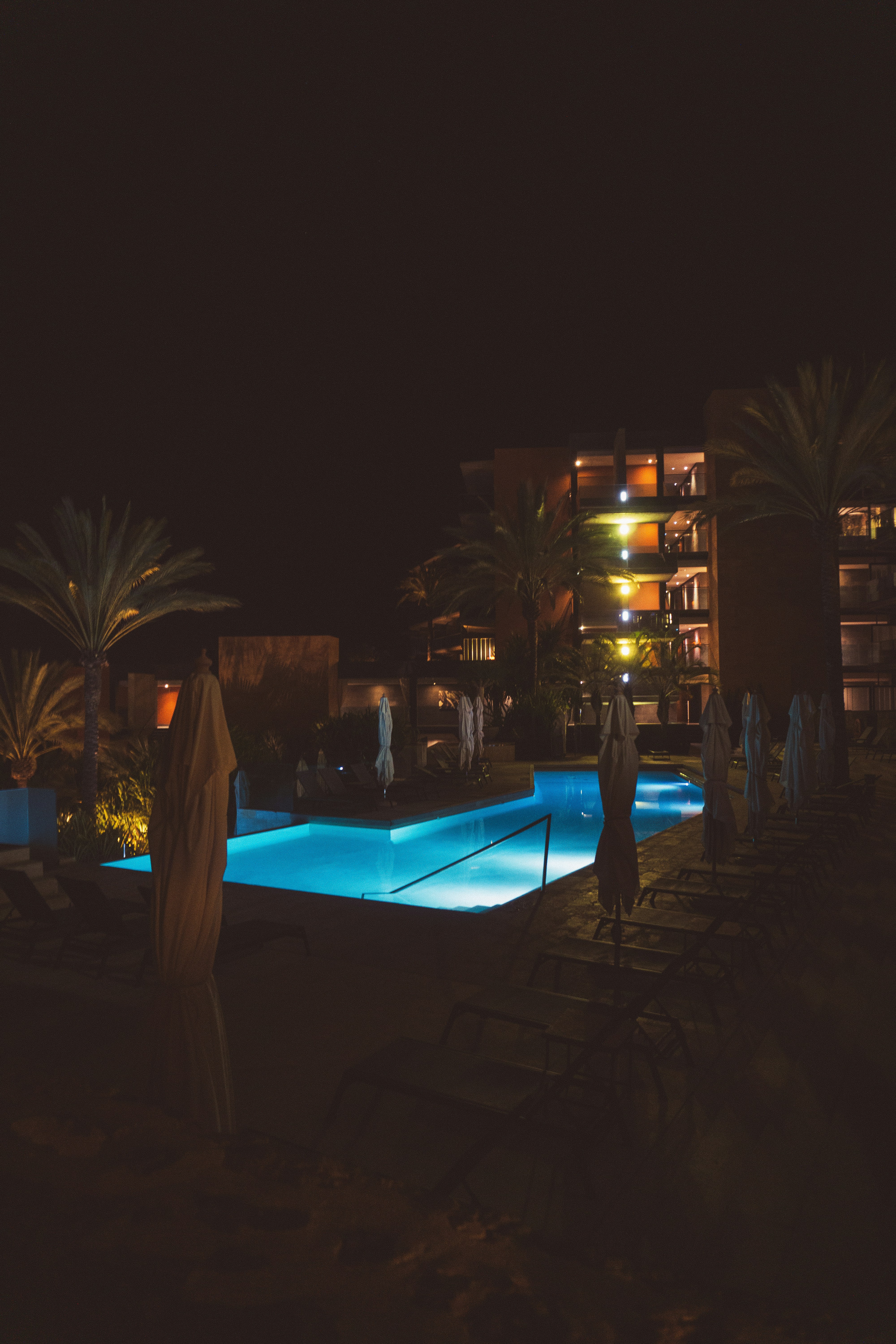 Azure Poollight: Night Oasis Beneath Palm-Studded Balconies
