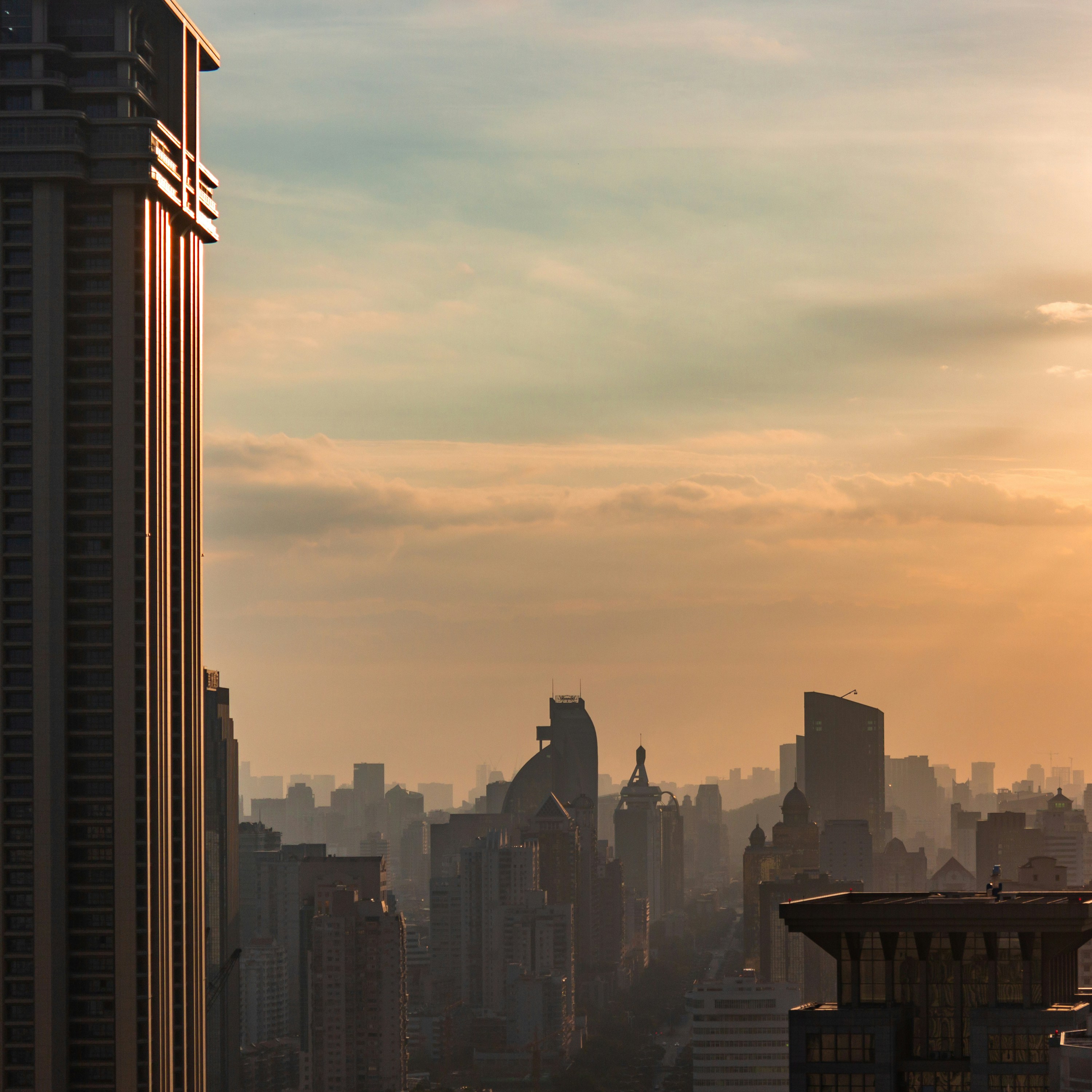 Dusk Framed by a Tower: Sunset Over a Layered City Silhouette
