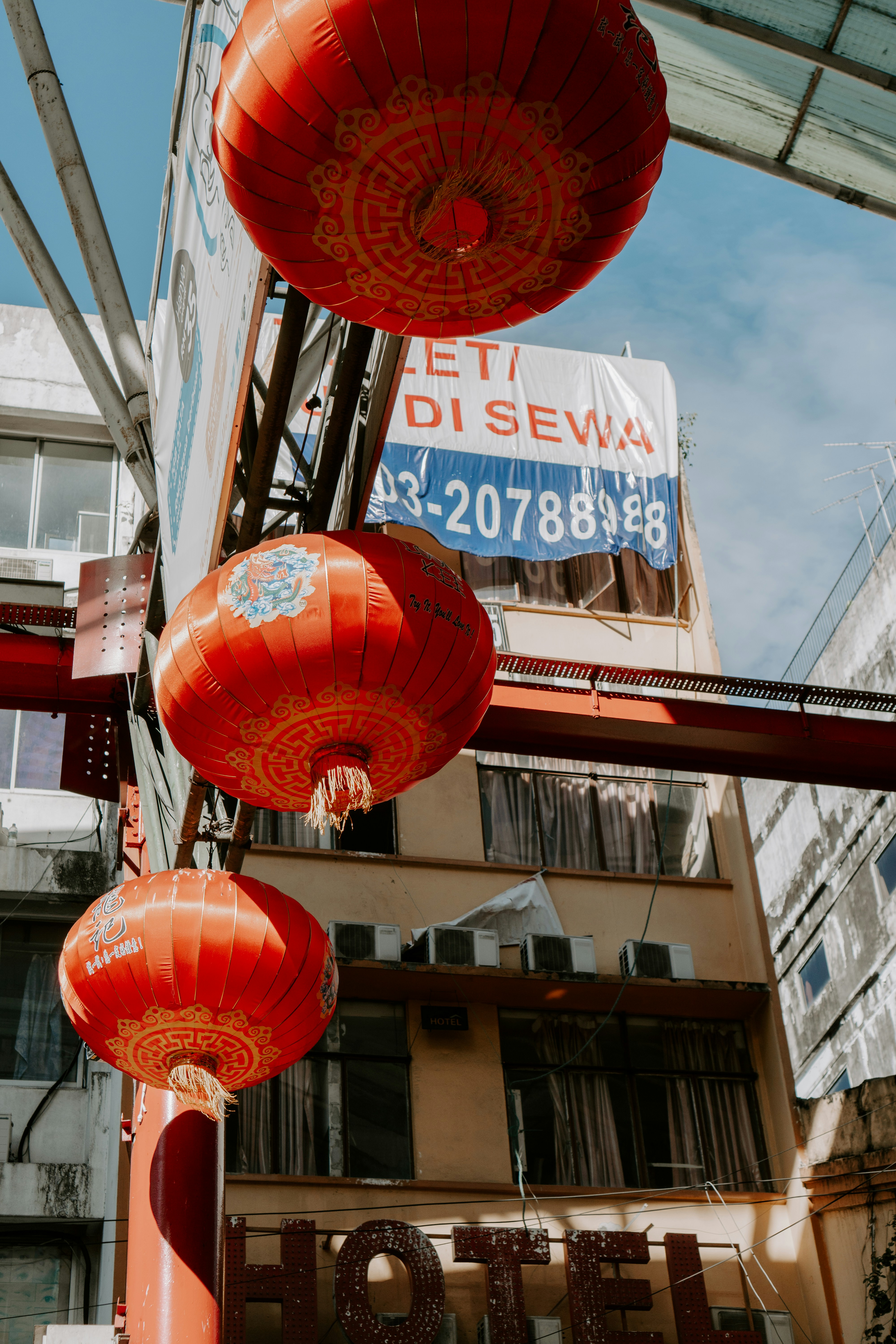 Crimson Lanterns Draped Over a Sunlit Hotel Facade