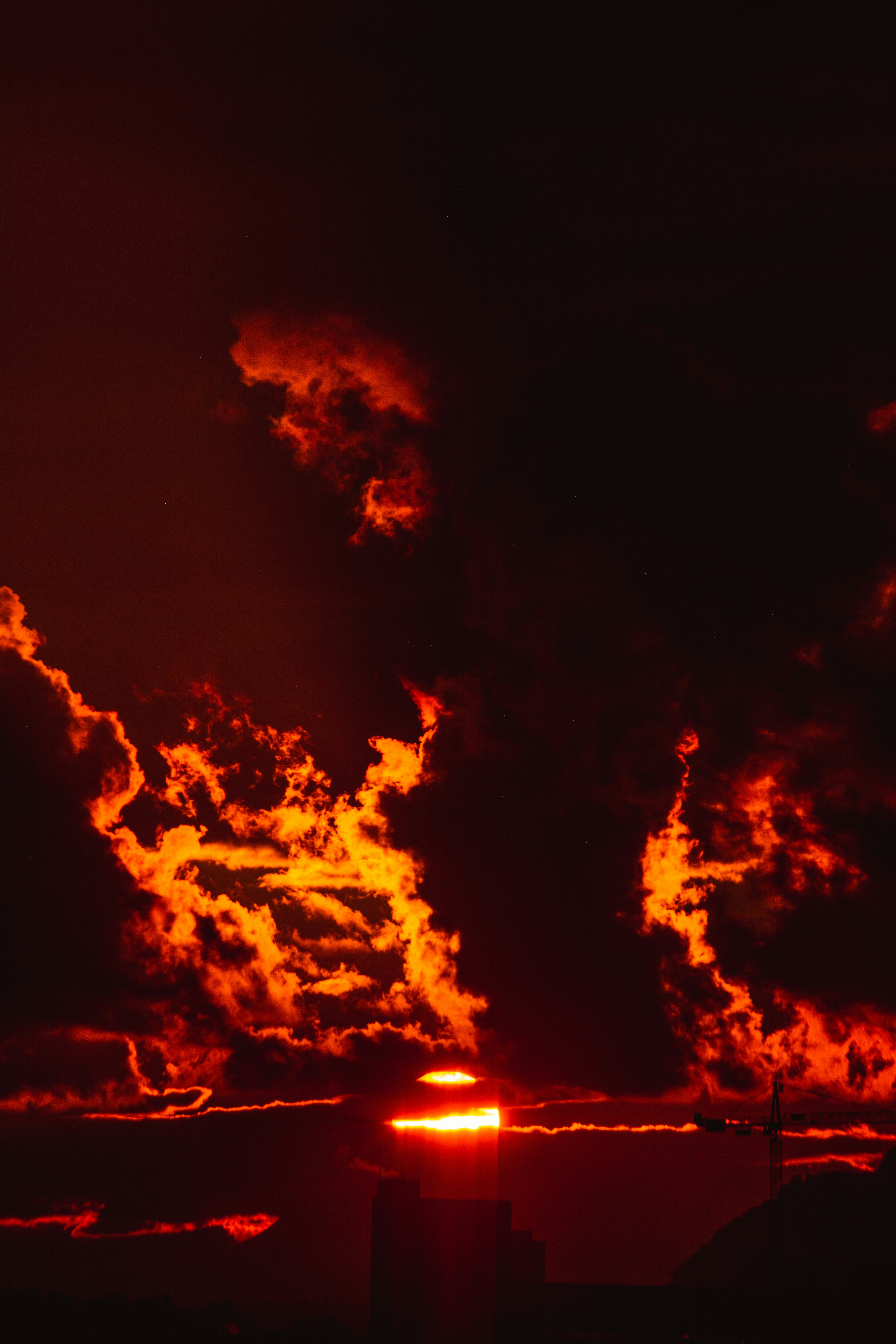 Ember Horizon: Crimson Clouds Crown a Silhouetted Cityscape at Dusk