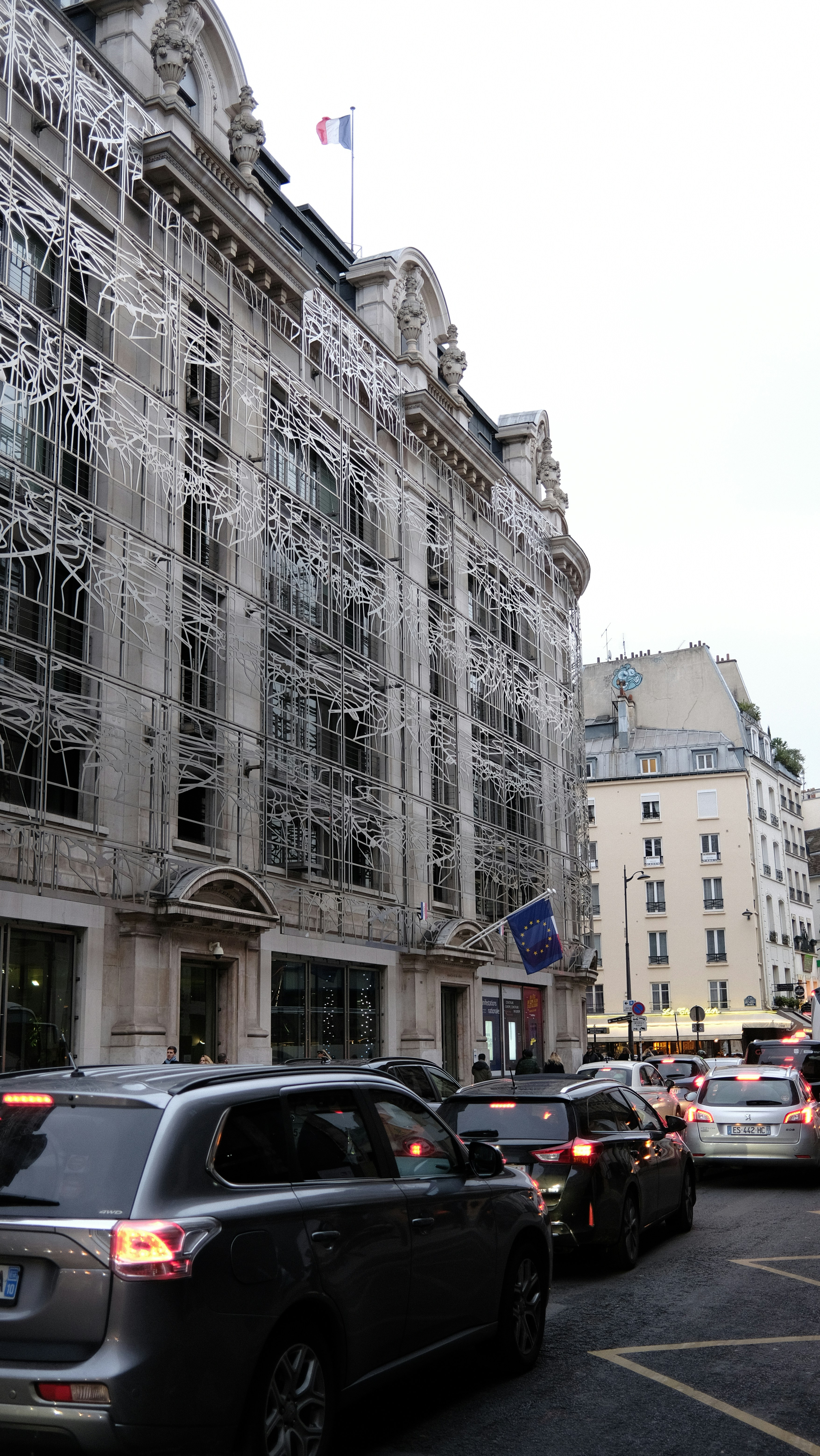 Ornate Facade Amid City Traffic: A Parisian Moment