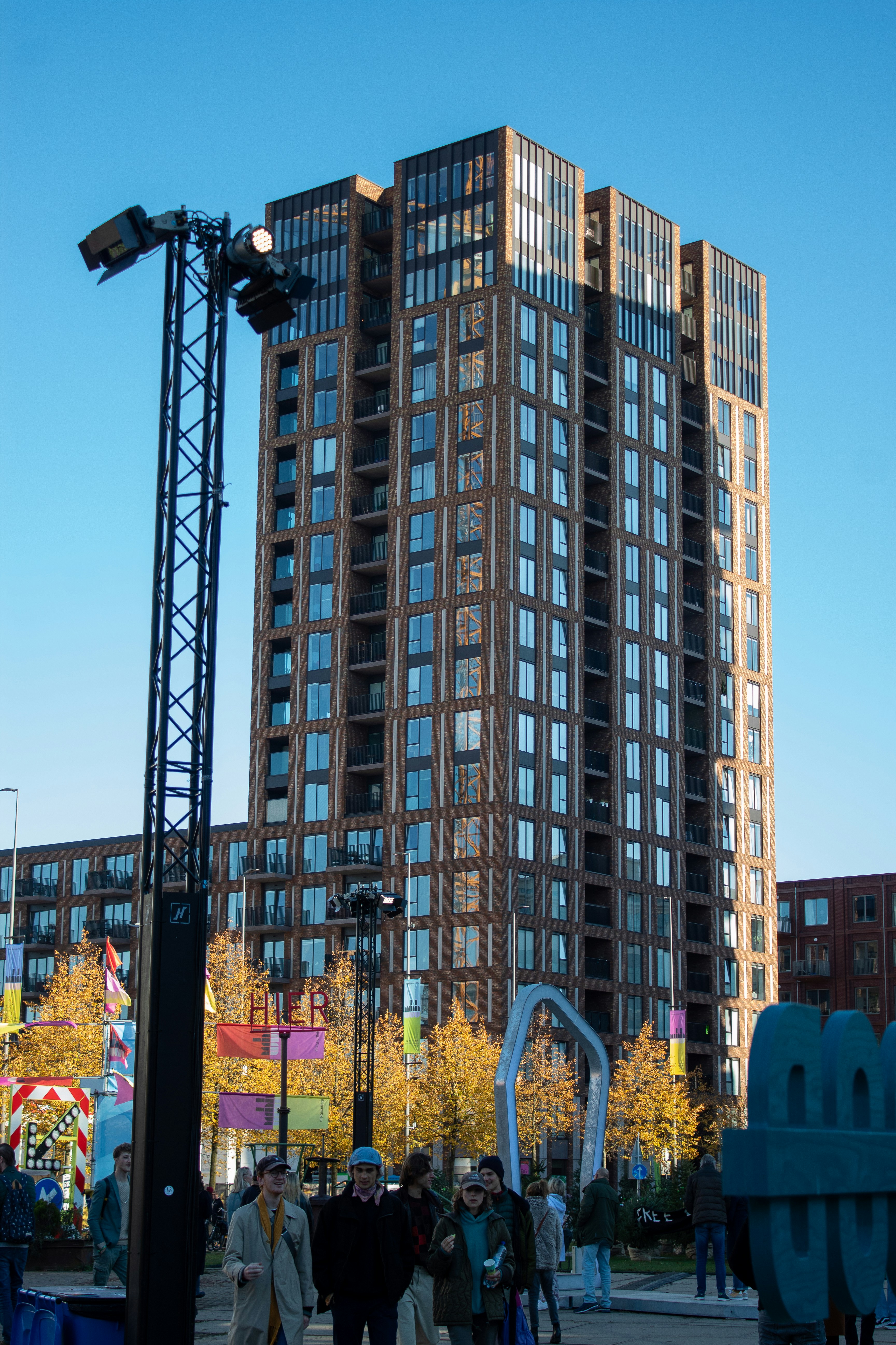 Brick-Clad Tower Dominates a Sunlit Urban Plaza