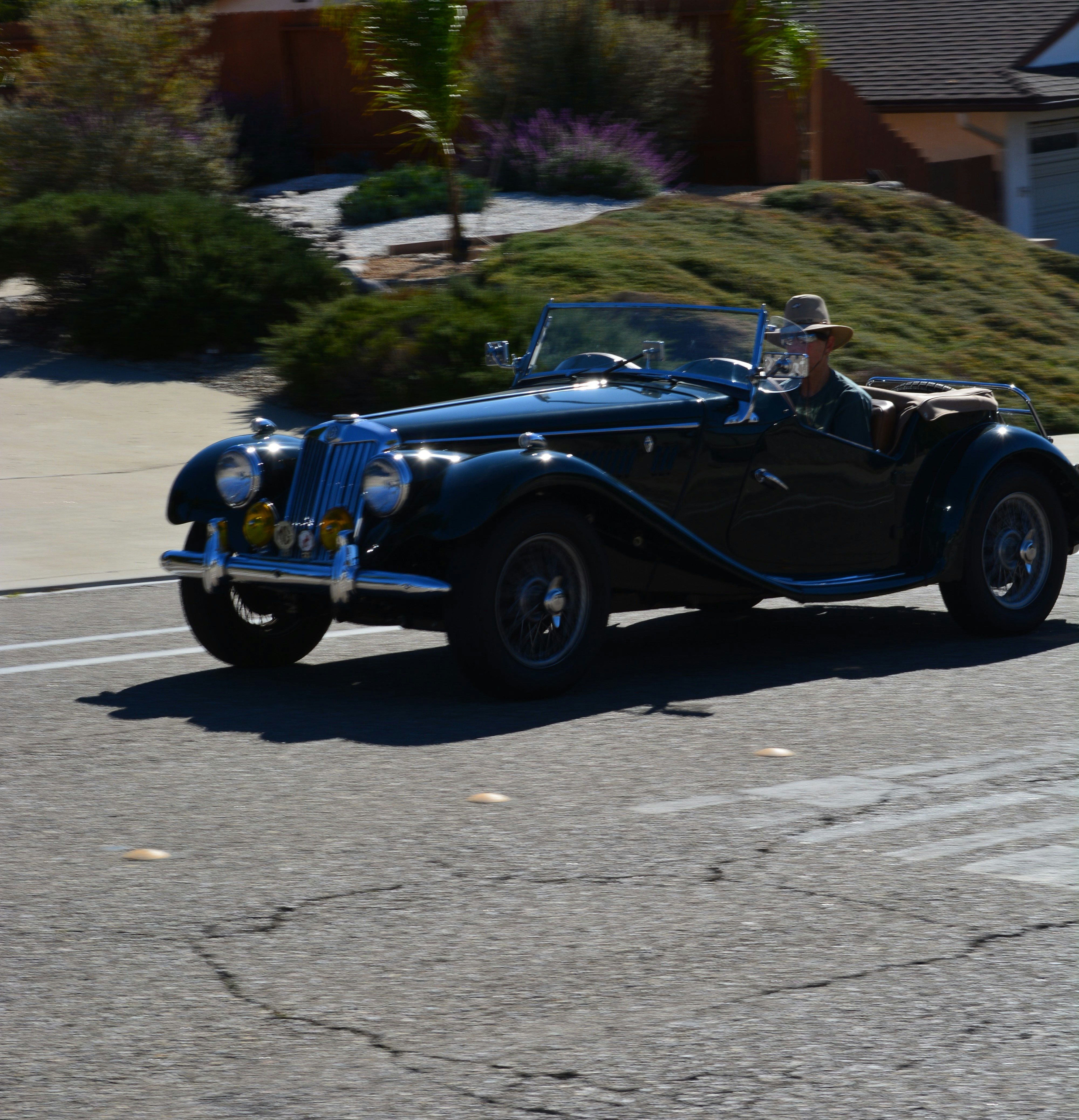 a person driving a blue convertible car