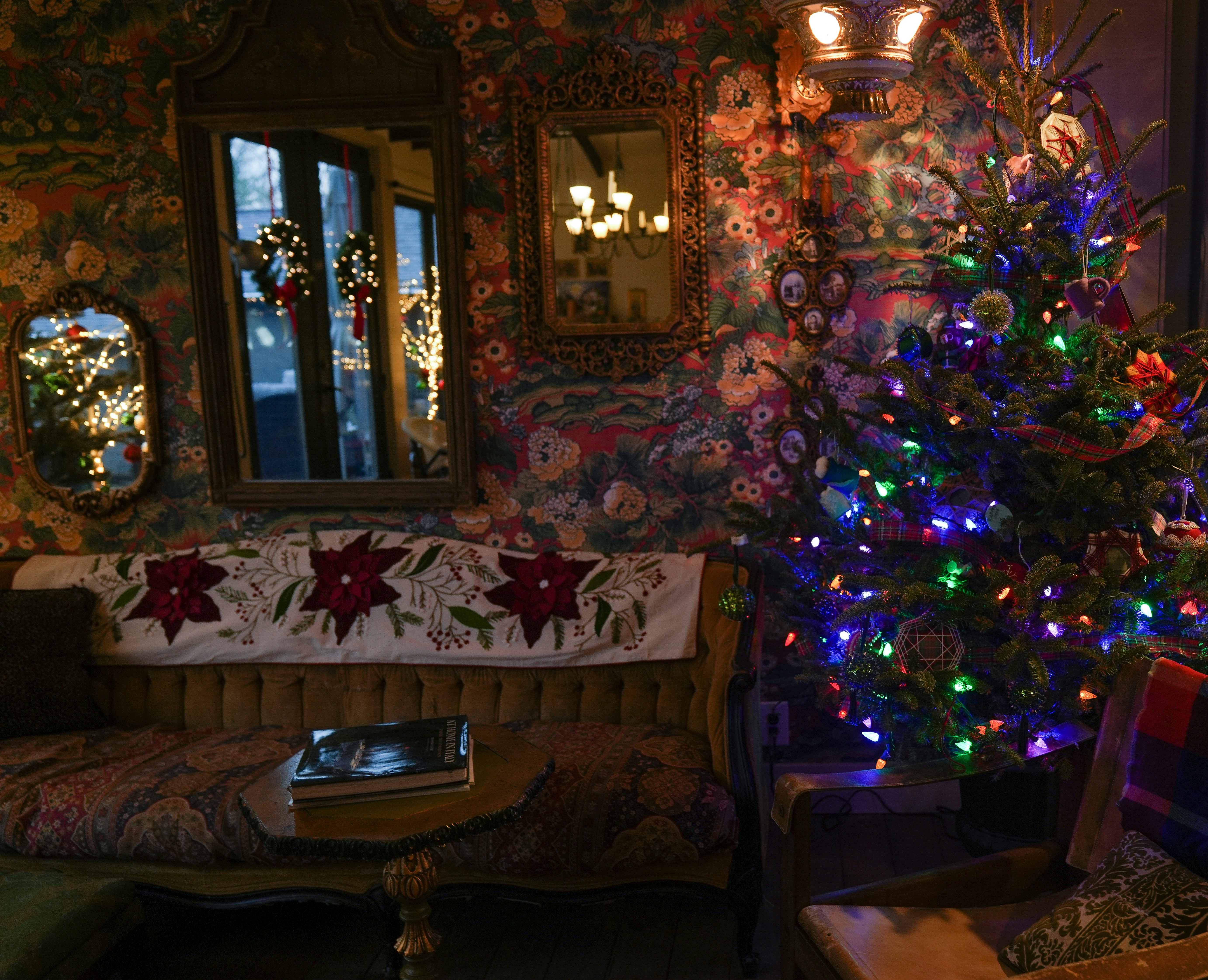 a room with a christmas tree and a mirror
