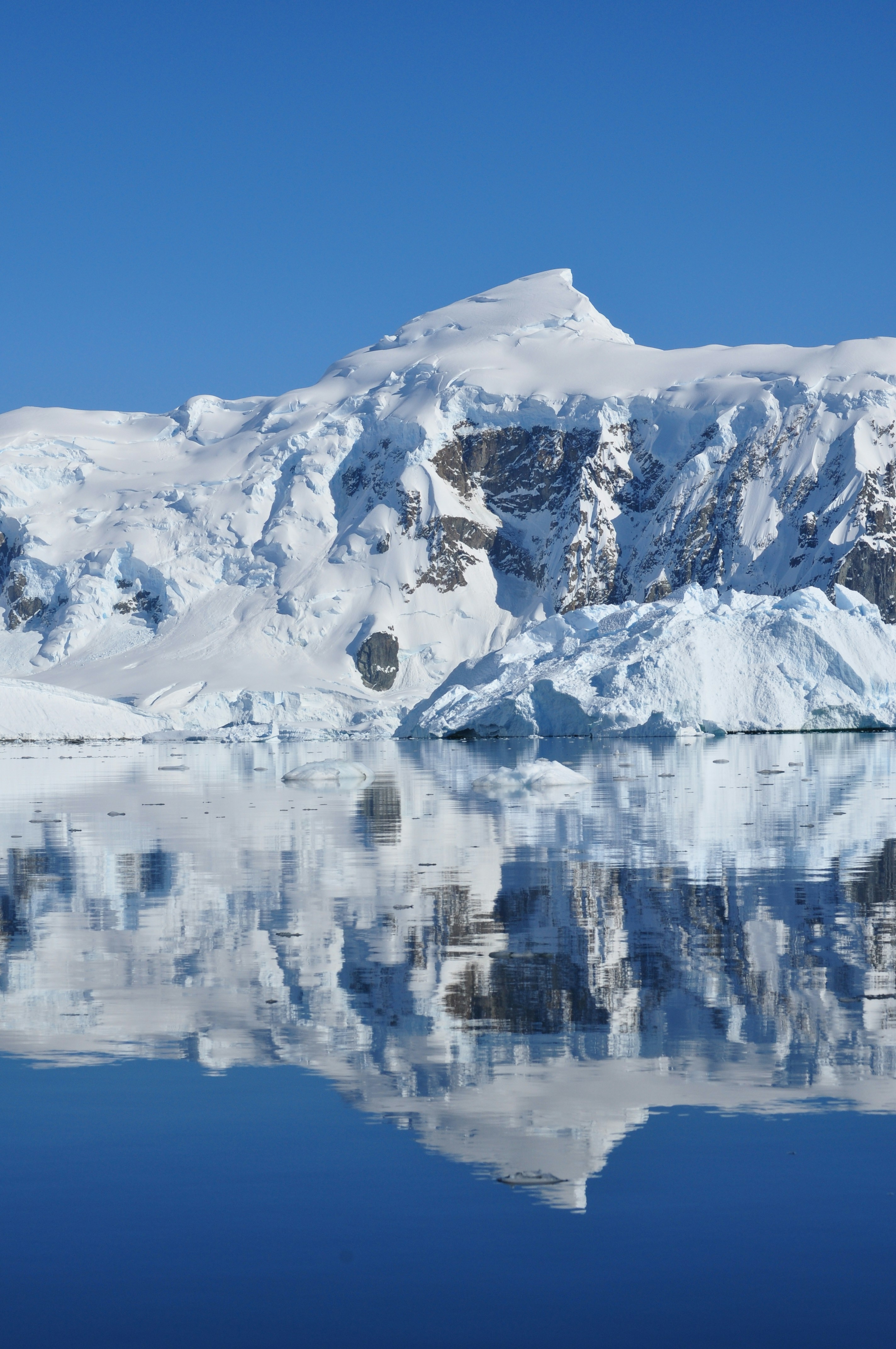 A snowy mountain with a body of water below photo – Free Antarctica ...