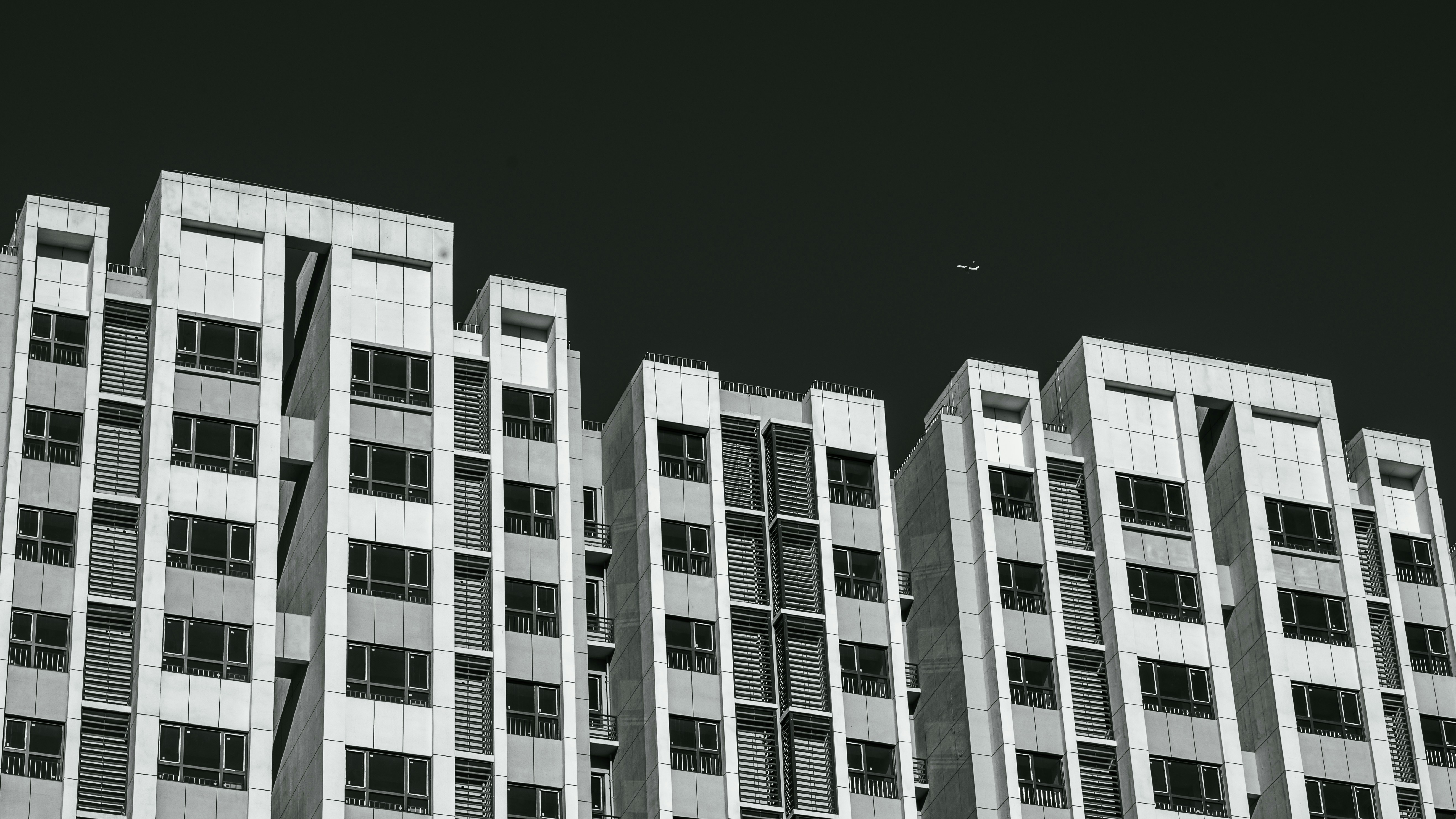 High-rise buildings with a stark contrast against a dark sky.
