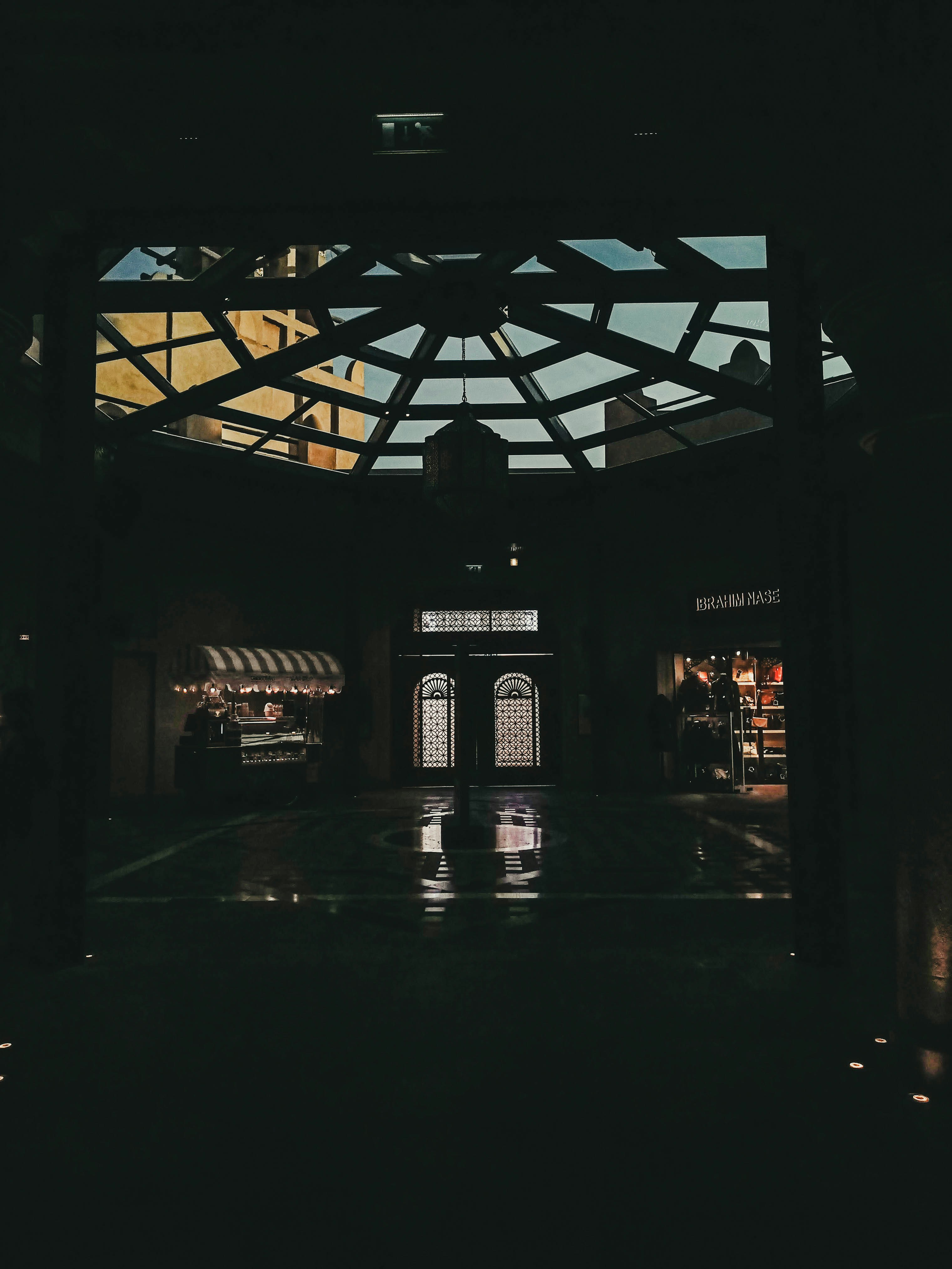 Intricate dome design casting shadows in a softly lit space, revealing glimpses of shops and a serene atmosphere.