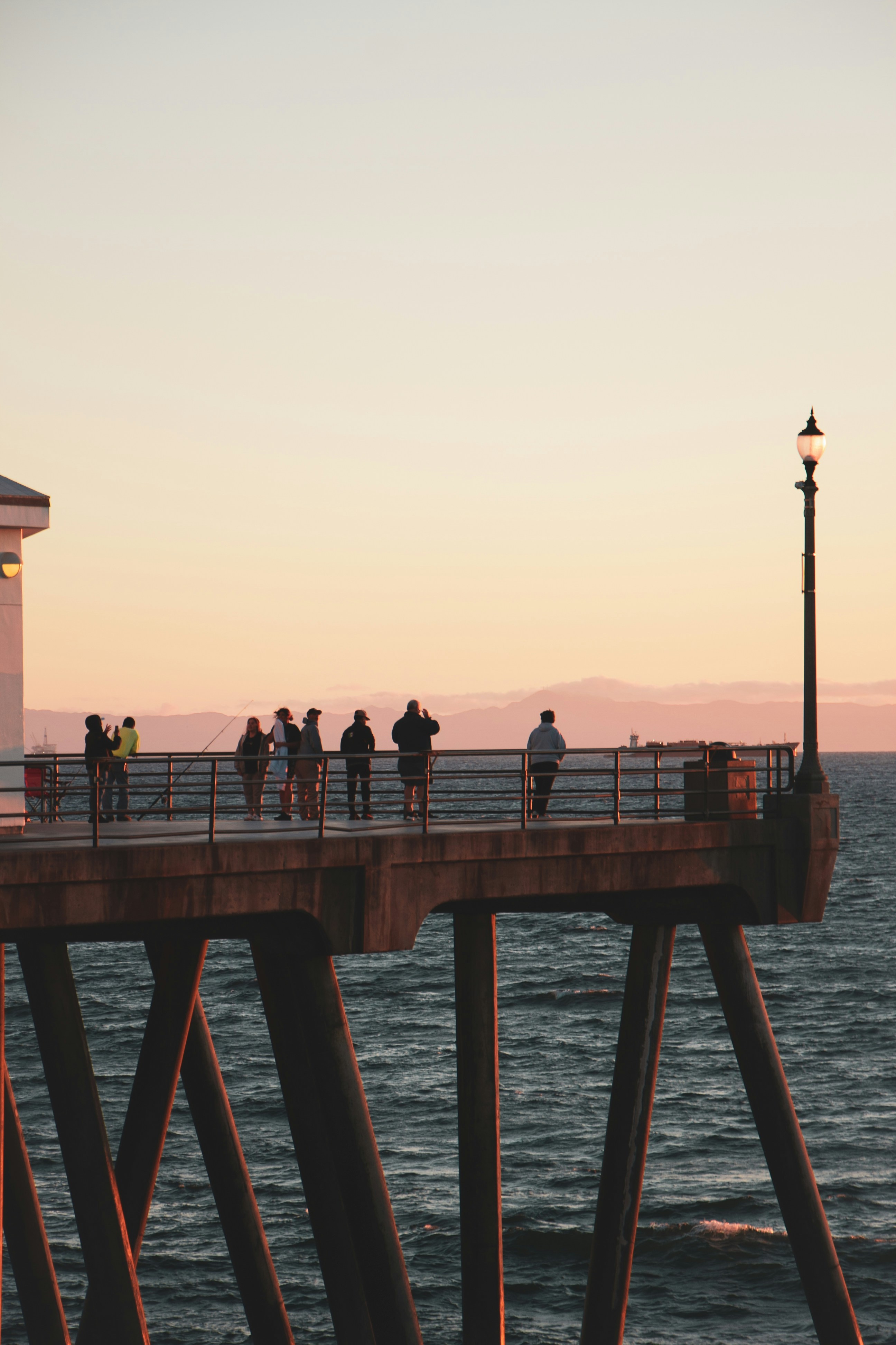 A group of people walking on a pier photo – Free Huntington beach Image ...